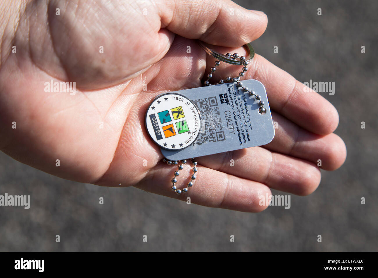 geocaching travelbug in the hand of geocacher Stock Photo - Alamy