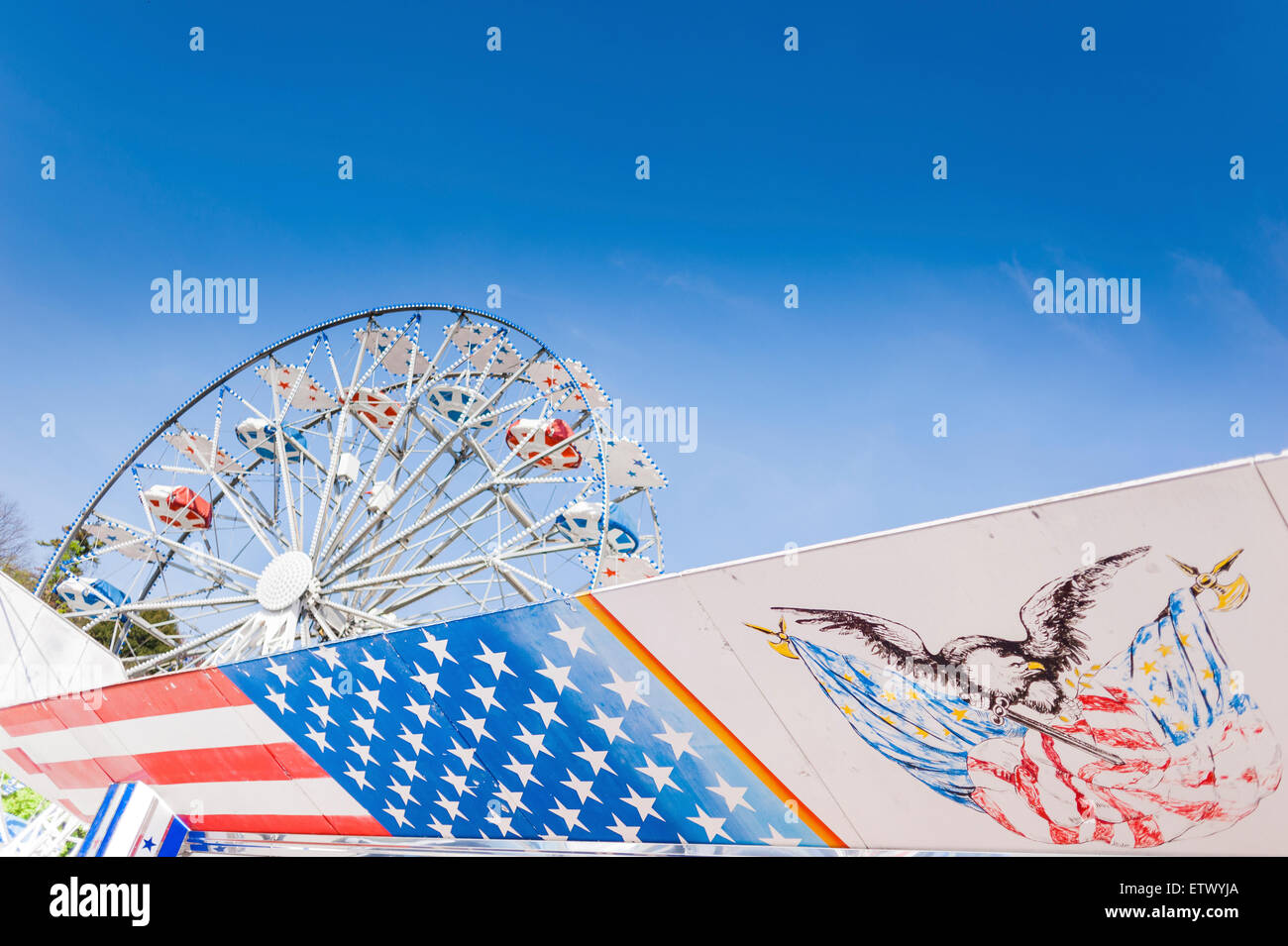 Symbols of the USA flag. In the background a Ferris wheel and the sky ...