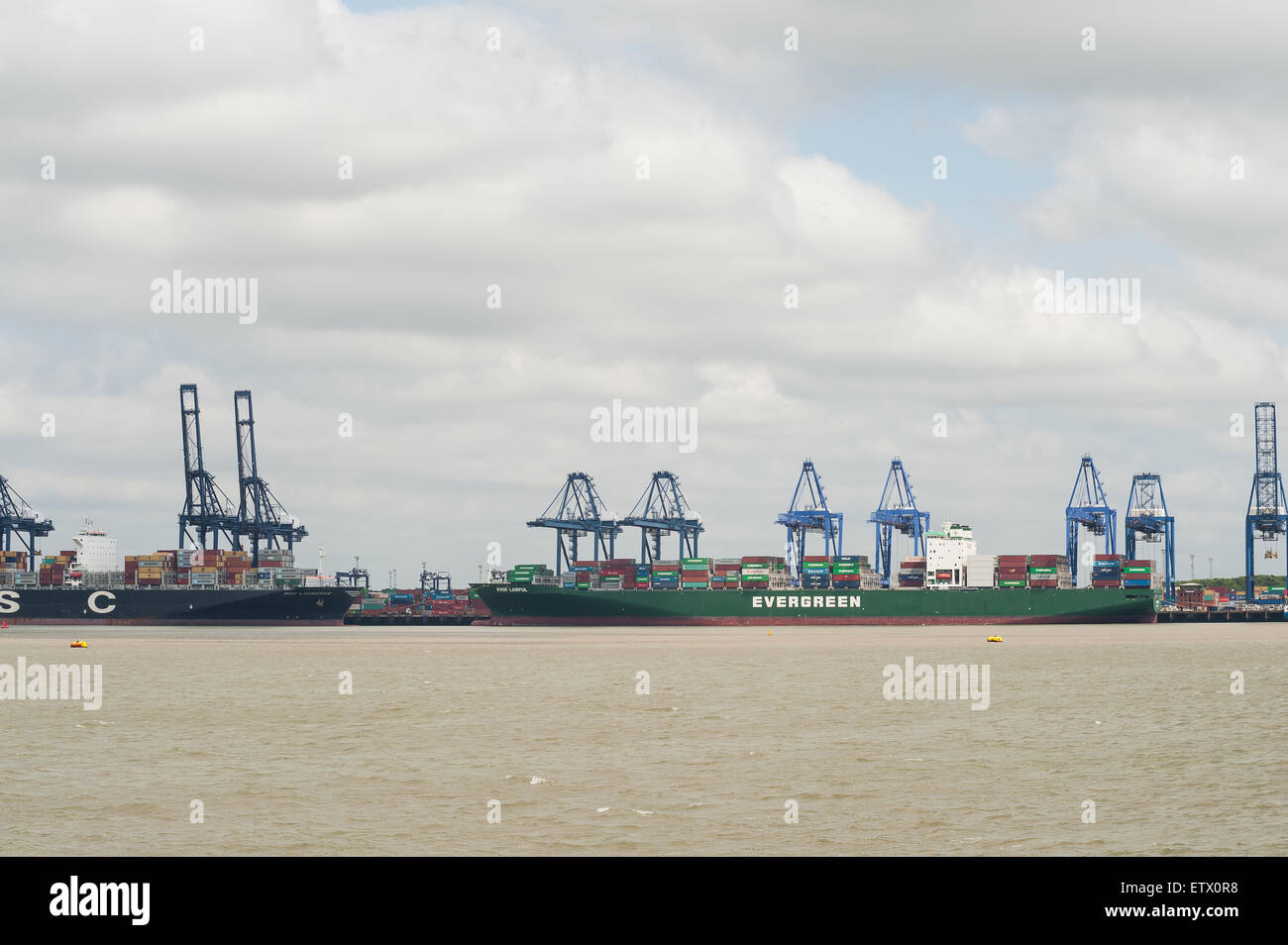 Felixstowe shipping port docks with massive cranes loading large ...