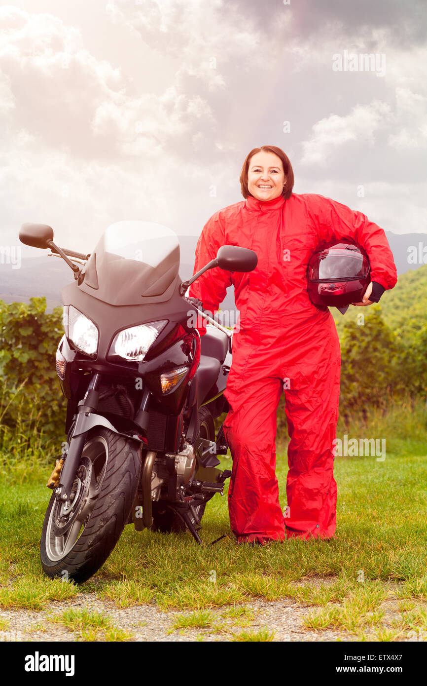 Motorcycle rider puts on rain protection Stock Photo - Alamy