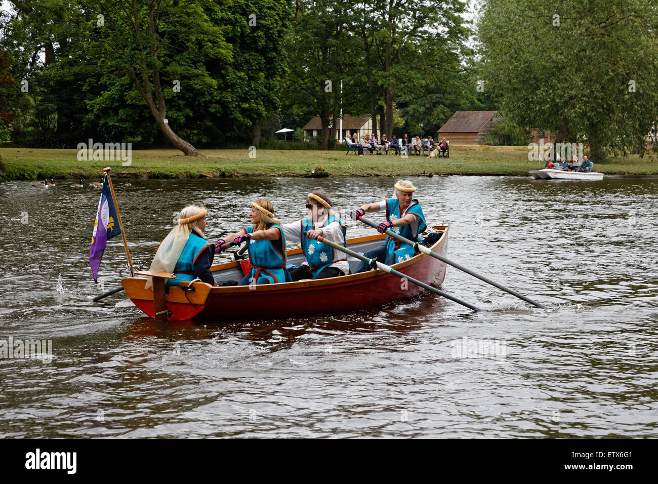 On the River Thames at Runnymede four women in a row boat are watched ...