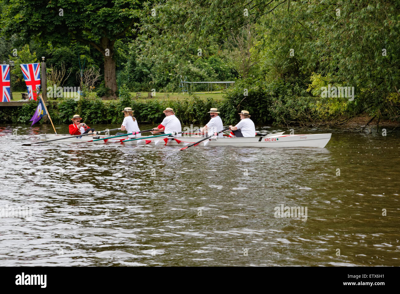 Coxed Four rowing on the River Thames at Runnymede in straw boaters and ...
