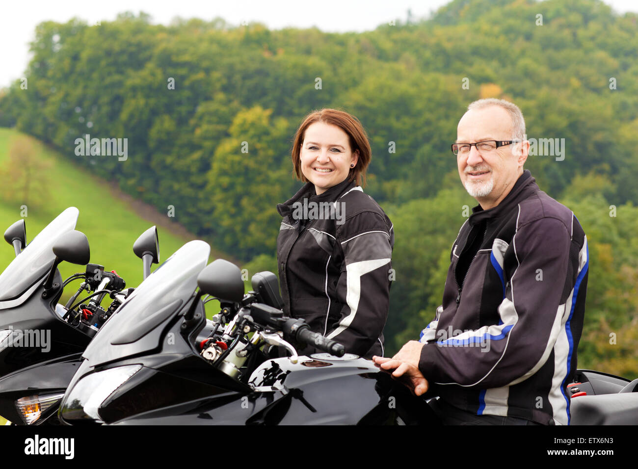 Two motorcyclists sitting on the bike Stock Photo - Alamy