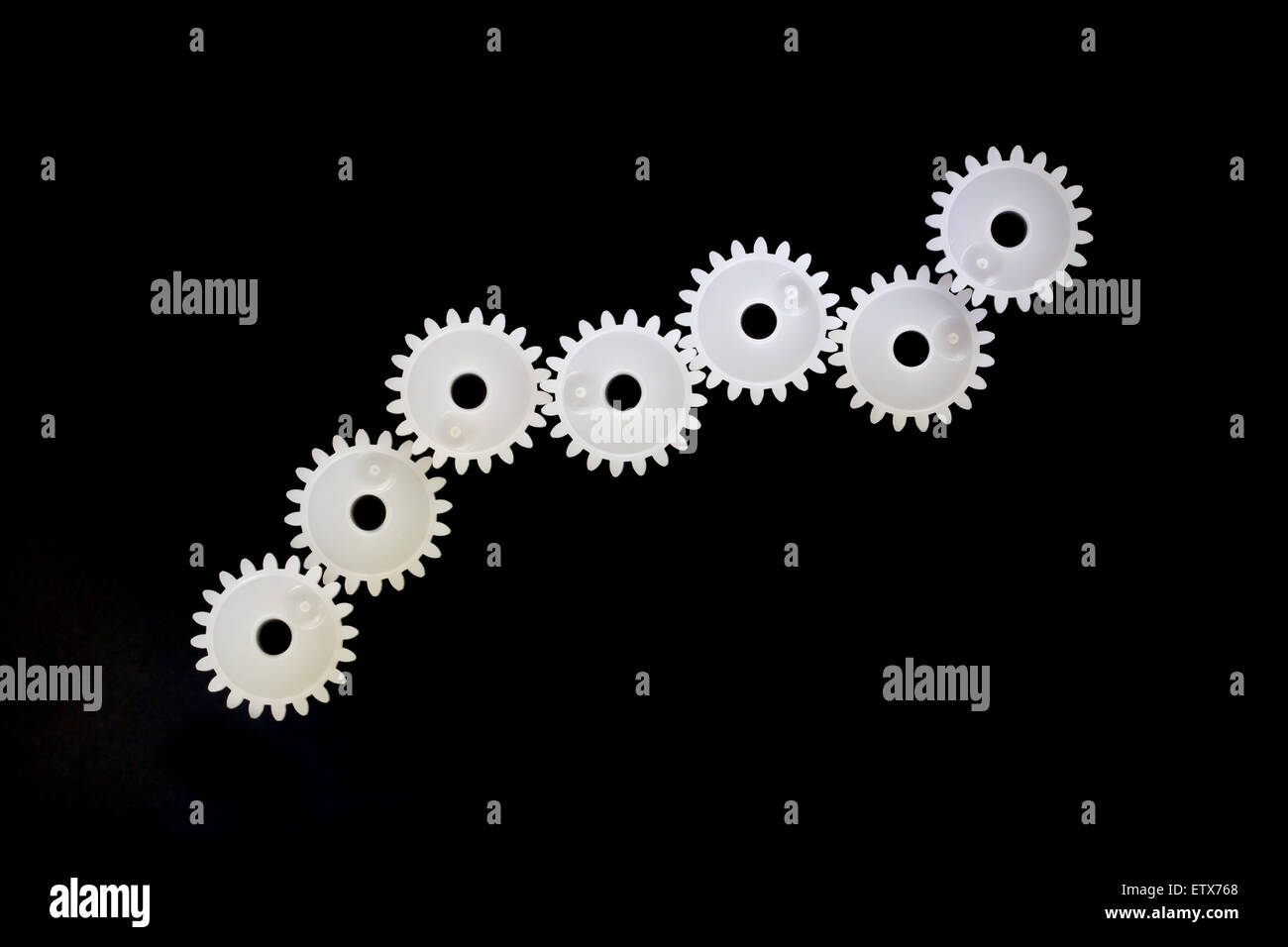 gears made of white plastic on black background Stock Photo - Alamy