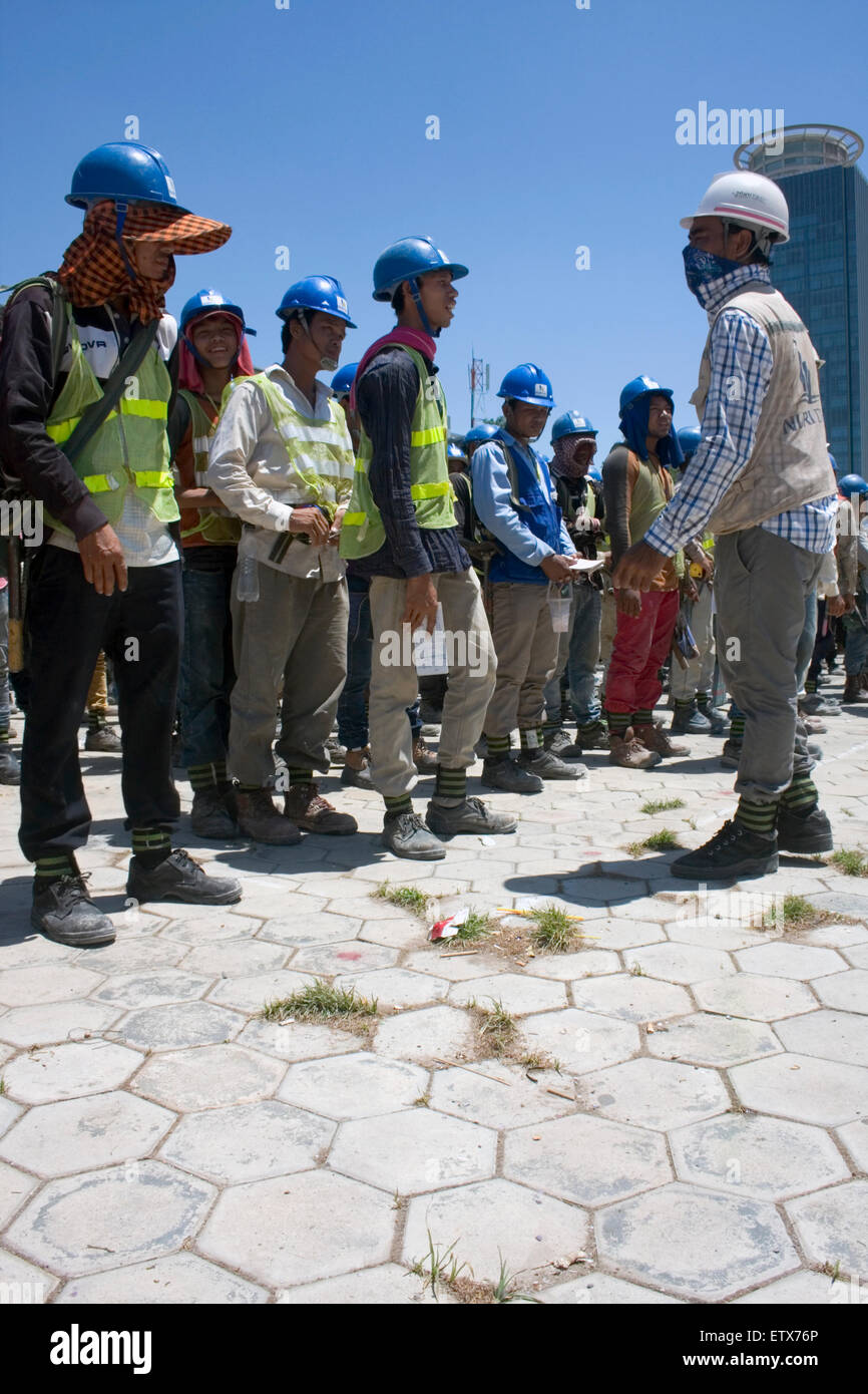 Construction workers take part in stretching exercises to enhance ...
