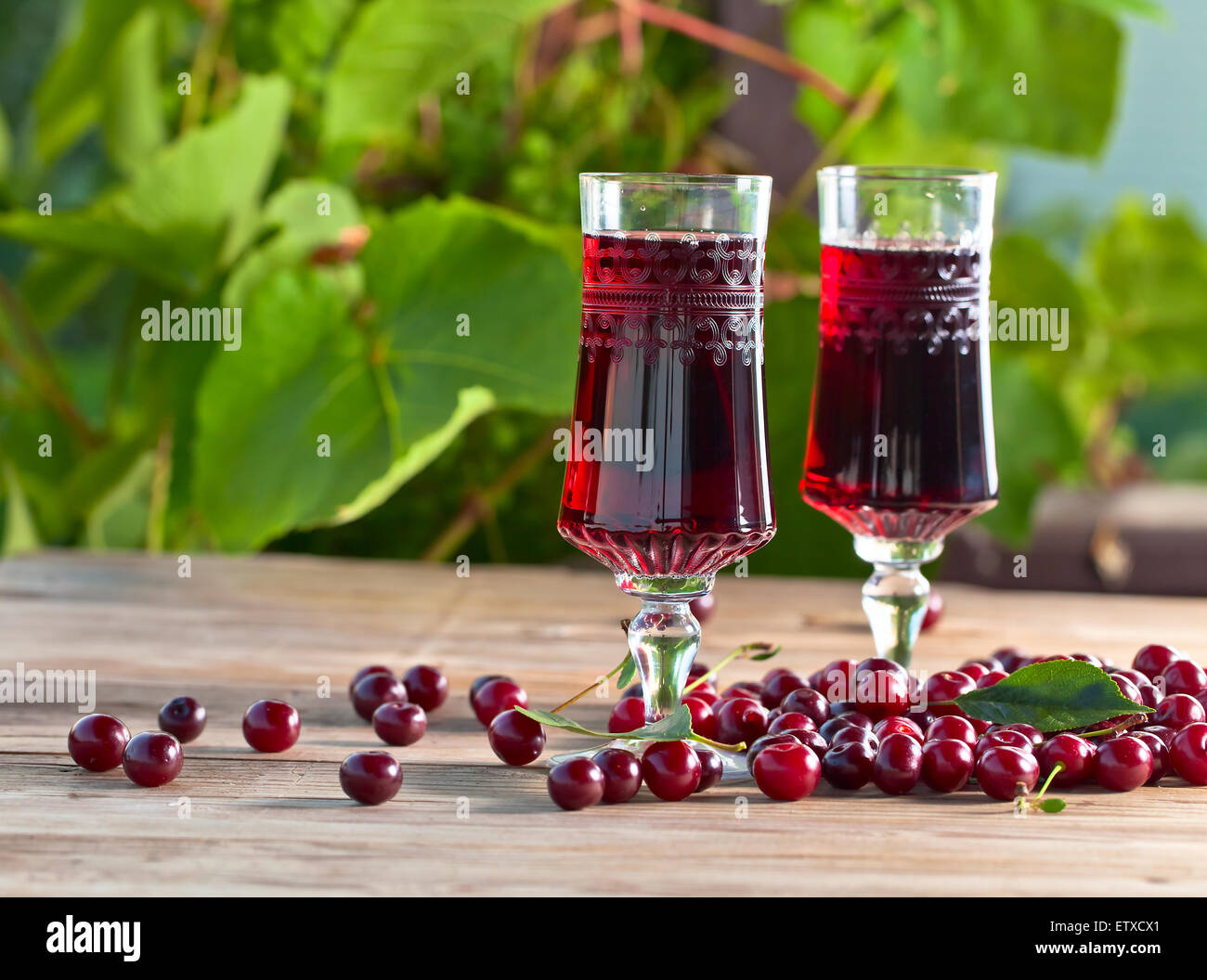 cherry brandy and ripe berries on wooden table Stock Photo - Alamy