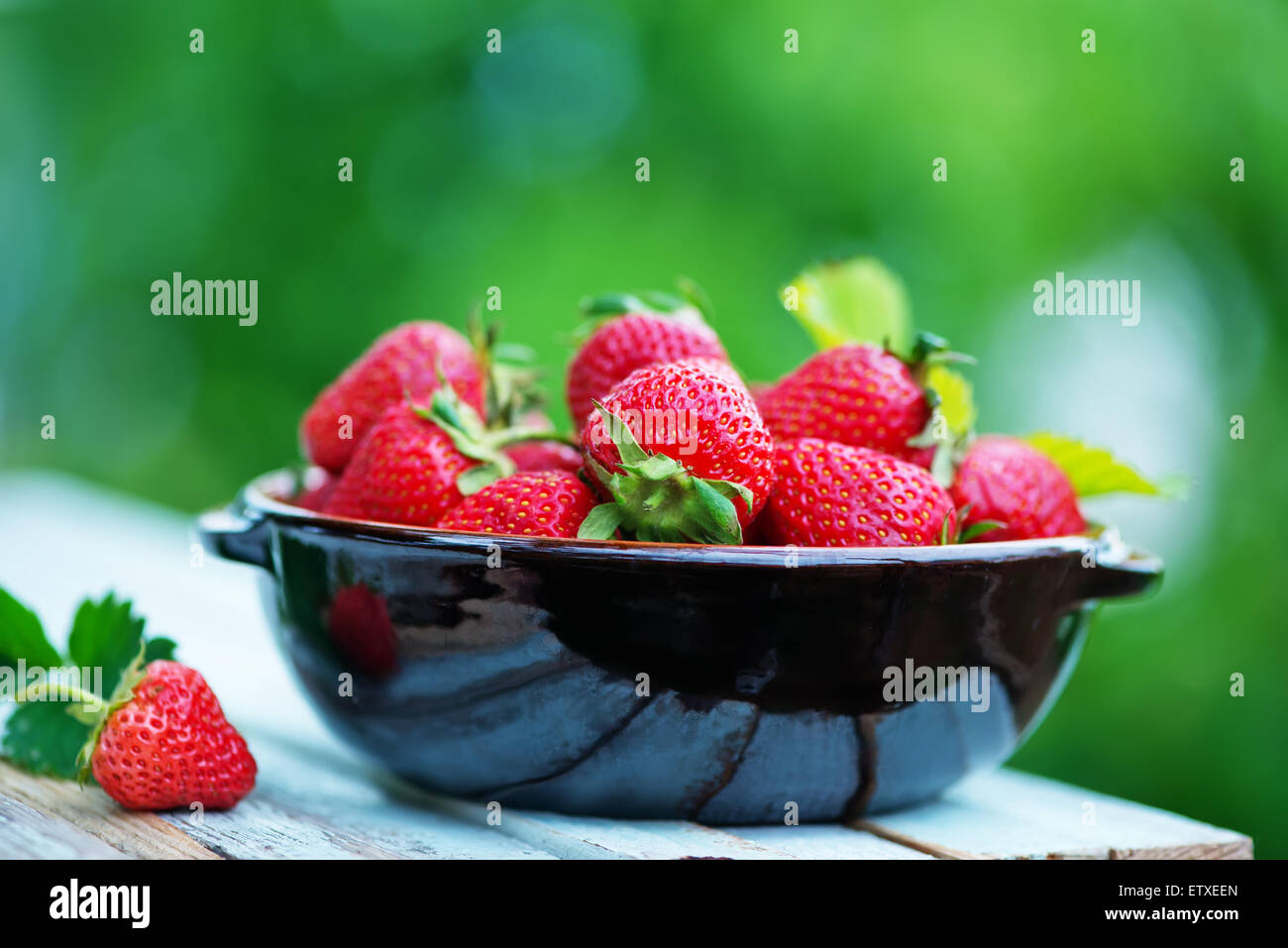 strawberry in bowl and on a table Stock Photo - Alamy