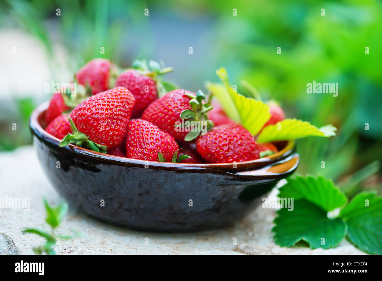 strawberry in bowl and on a table Stock Photo - Alamy