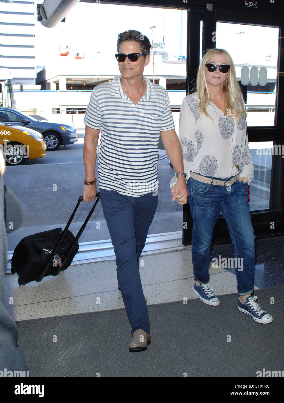 Rob Lowe holds hands with his wife Sheryl Berkoff as they arrive at Los ...