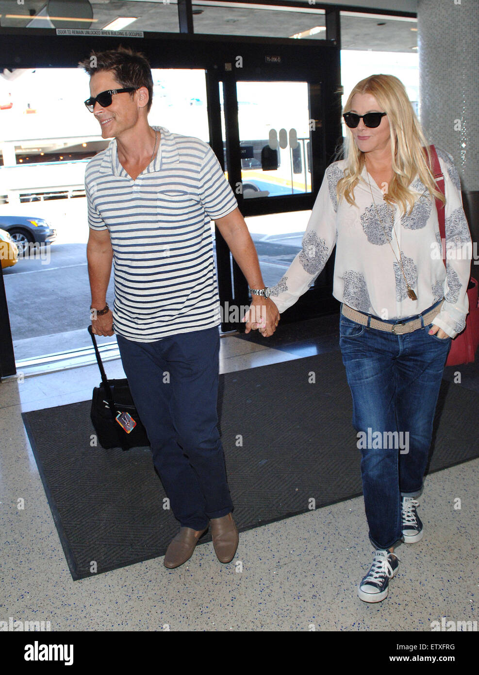 Rob Lowe holds hands with his wife Sheryl Berkoff as they arrive at Los ...