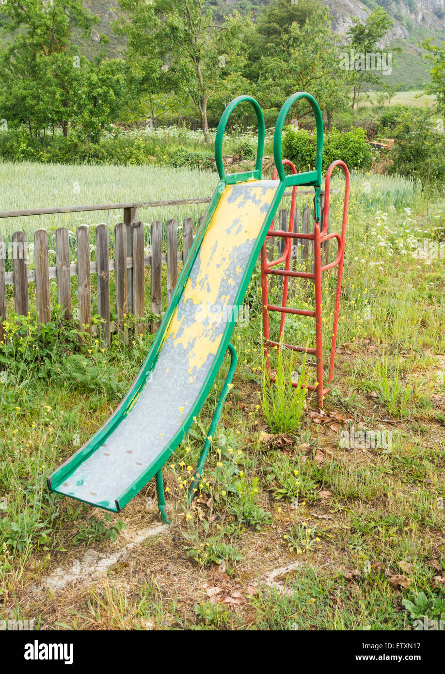 Children`s slide in overgrown playground in rural village in Spain ...