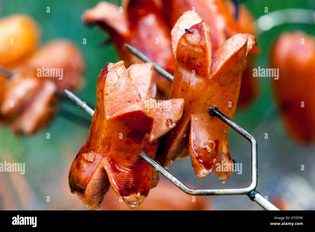 Sausage on stick over fire, bonfire party Stock Photo - Alamy