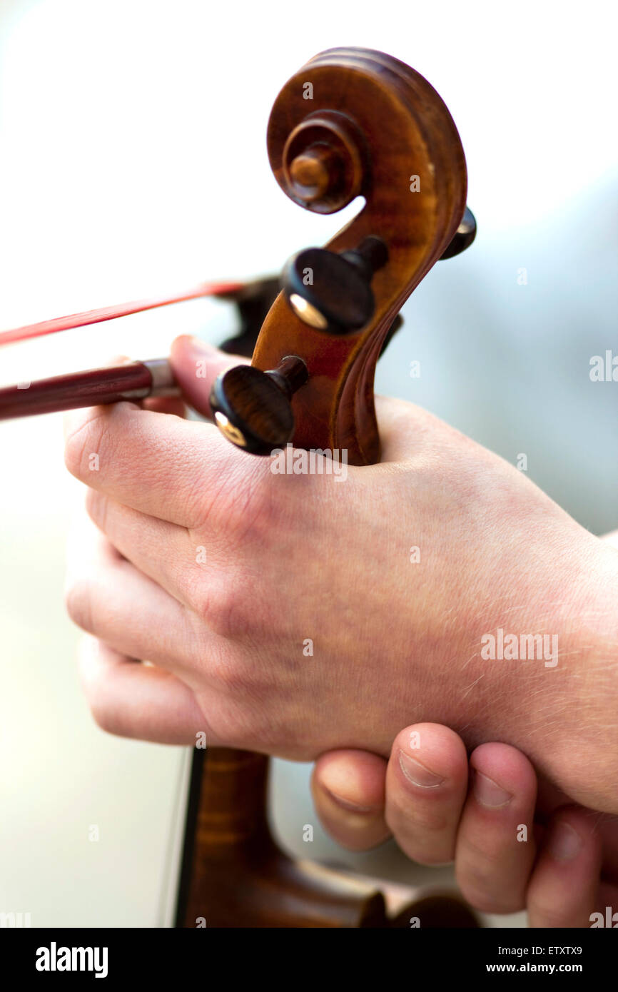 Close up of a hand holding a violin Stock Photo - Alamy