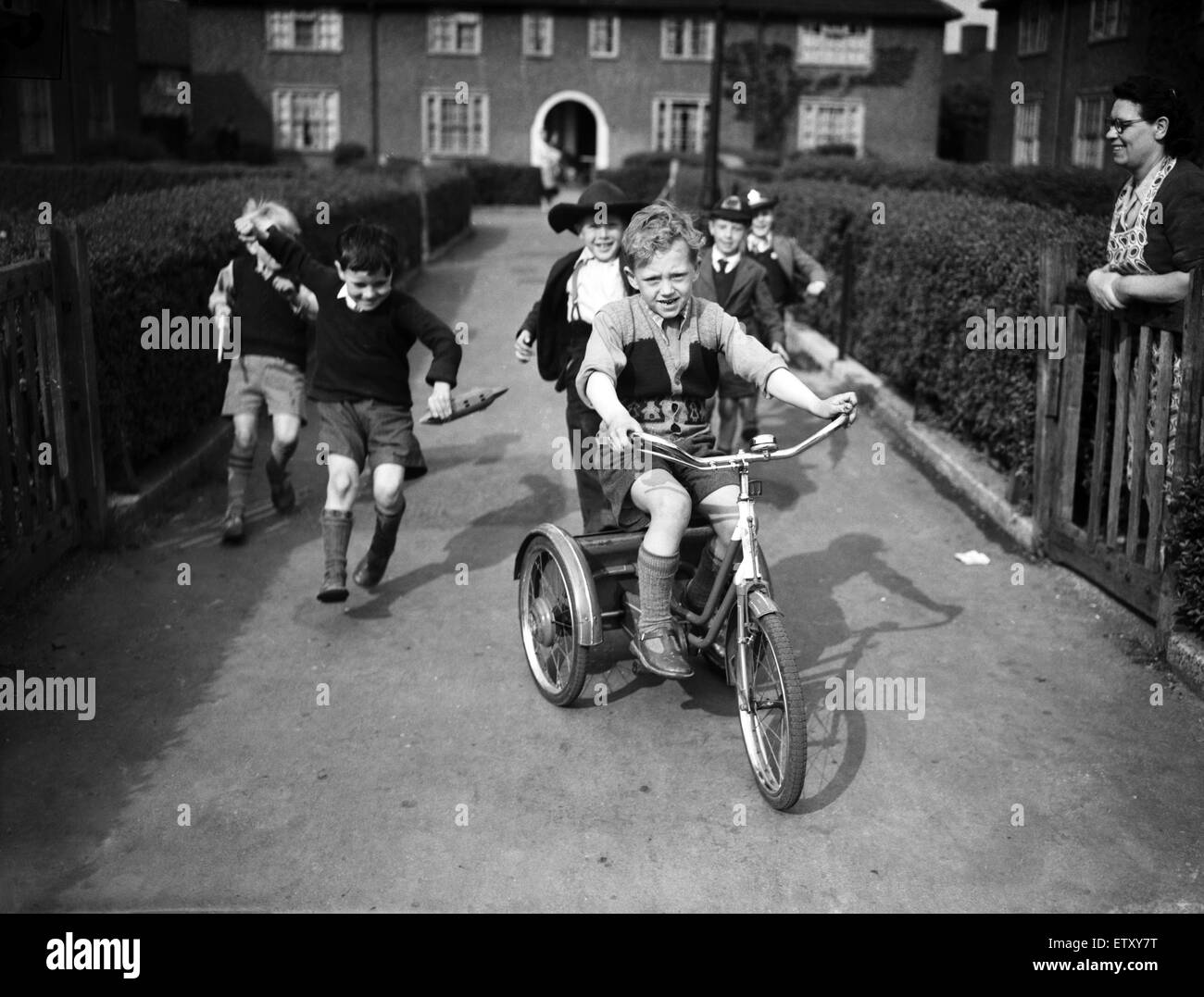 Boys playing on a council estate as one of their mothers looks on ...