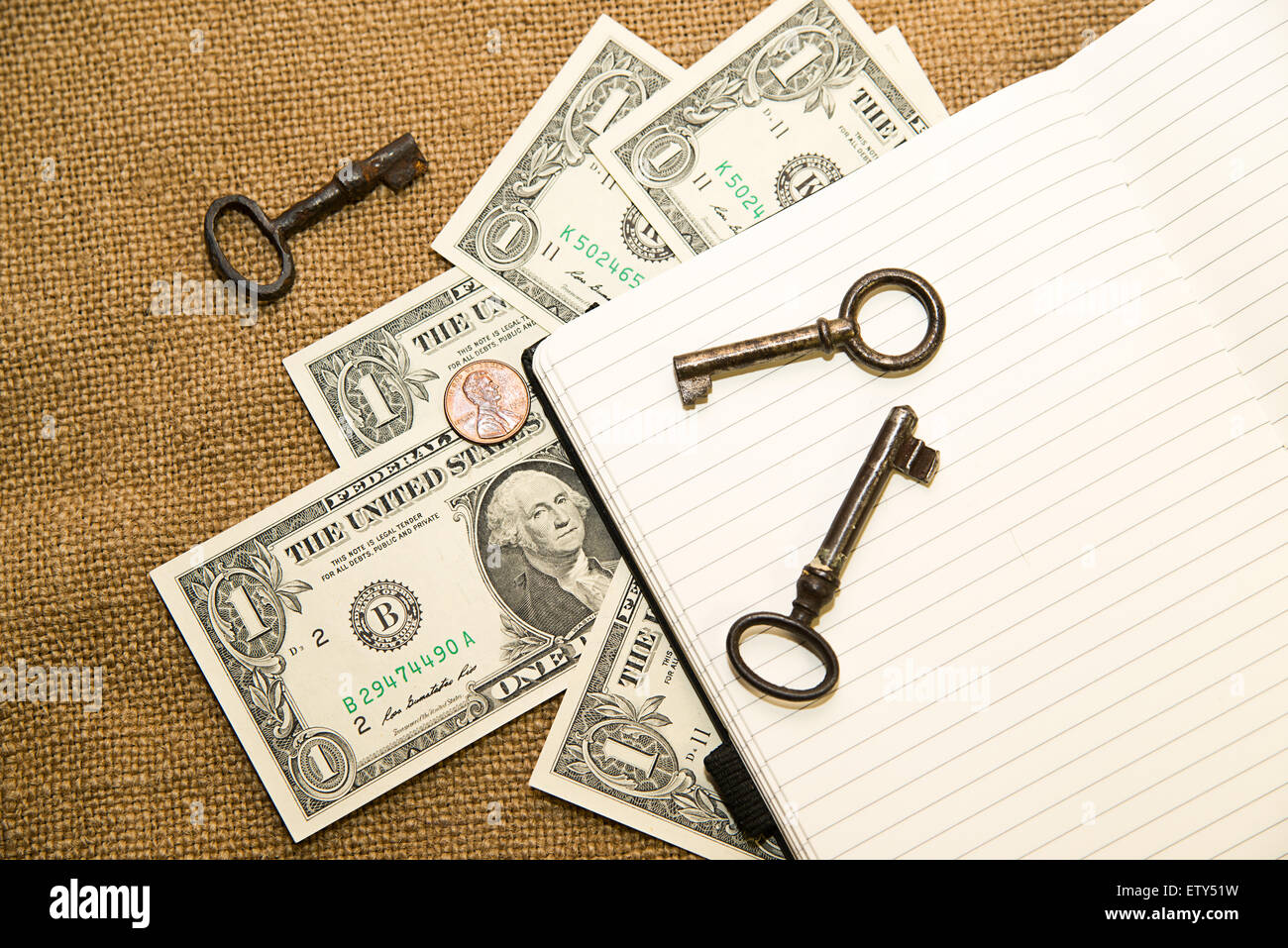 Opened notebook with a blank sheet, keys and money on the old tissue ...