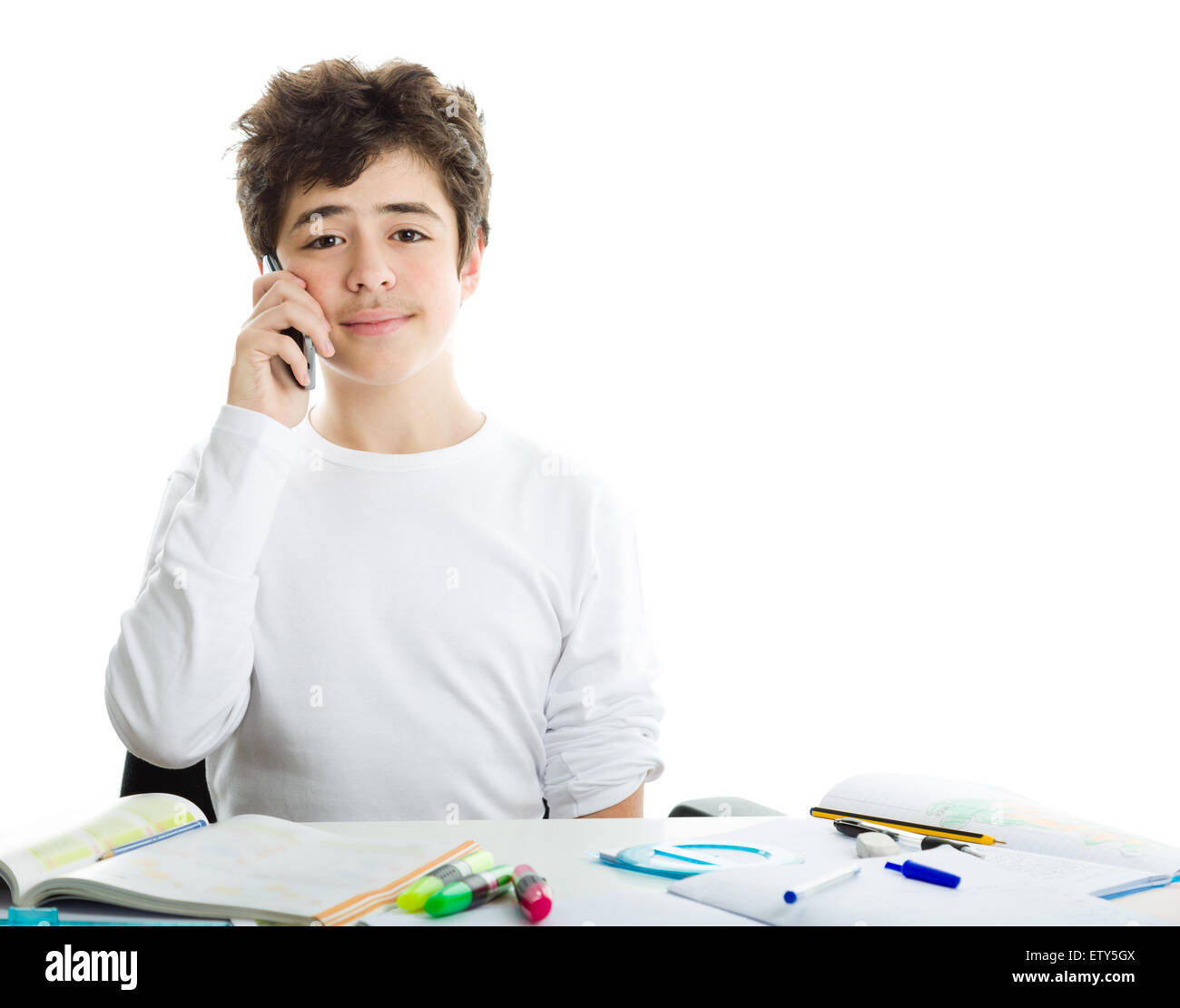 Smiling handsome Hispanic boy is talking on cell phone while doing ...