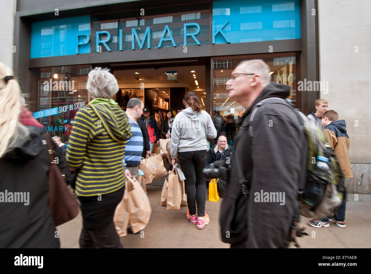 Shoppers sitting outside Primark in Oxford Street tired from bargain ...