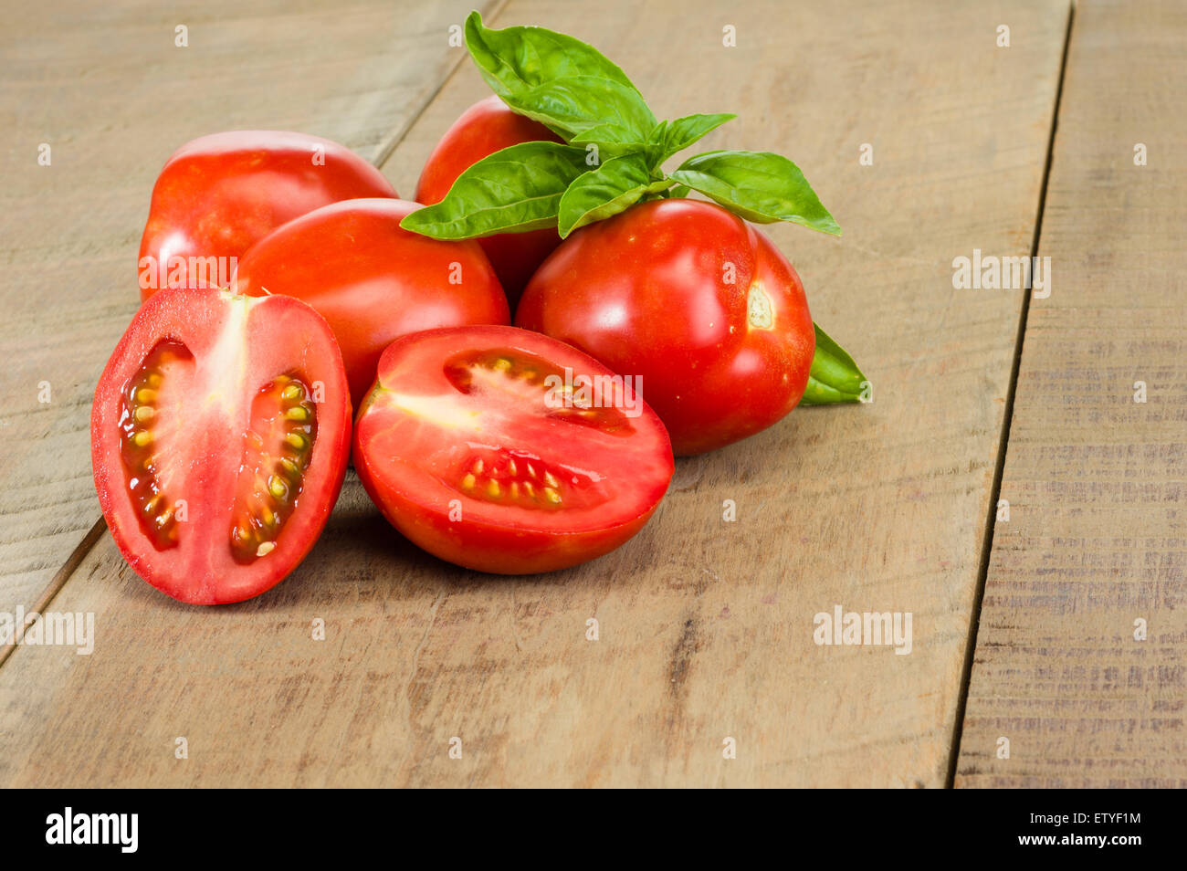 Fresh sliced red paste tomatoes with basil Stock Photo - Alamy