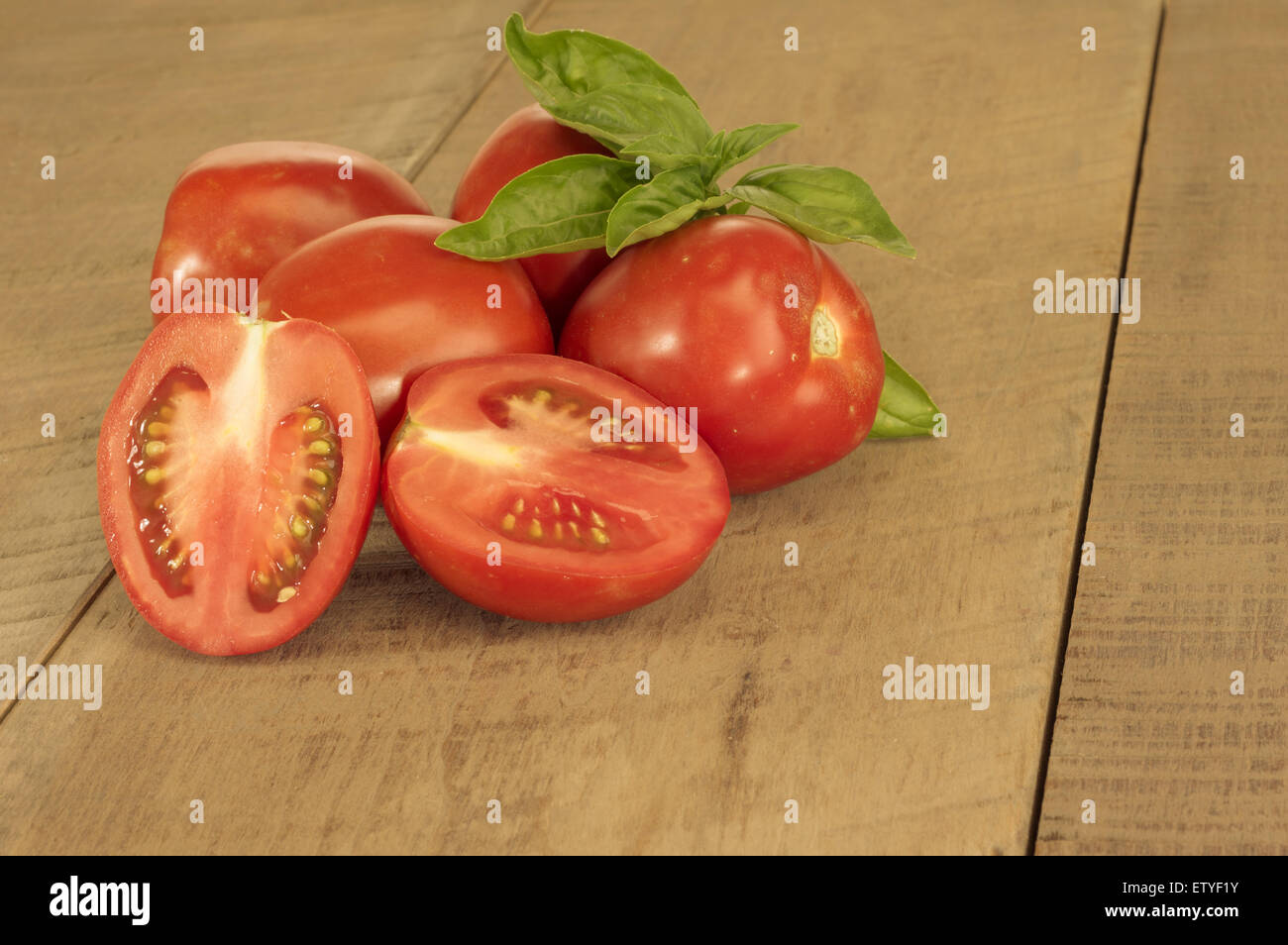 Fresh red paste tomatoes on a wooden table faded Stock Photo - Alamy