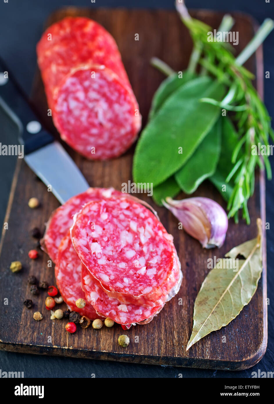 salami and knife, salami on black table Stock Photo - Alamy
