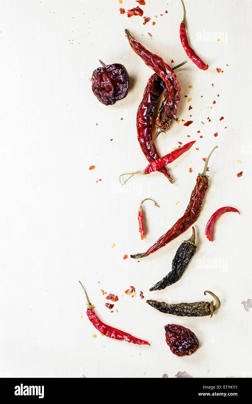 Assortment of dryed red hot chili peppers over white wooden background ...