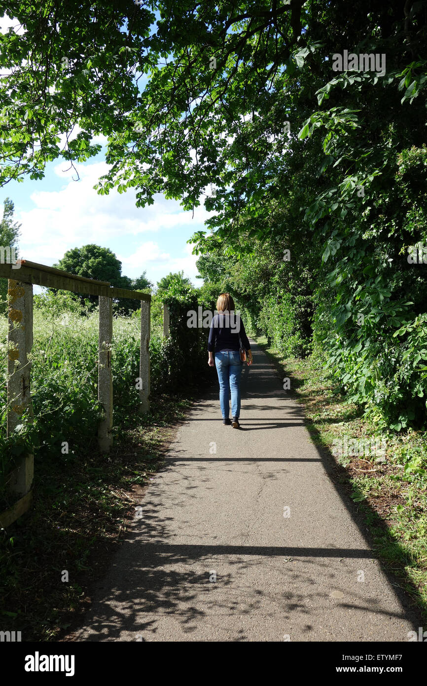 Back view of woman walking along footpath in park Stock Photo - Alamy