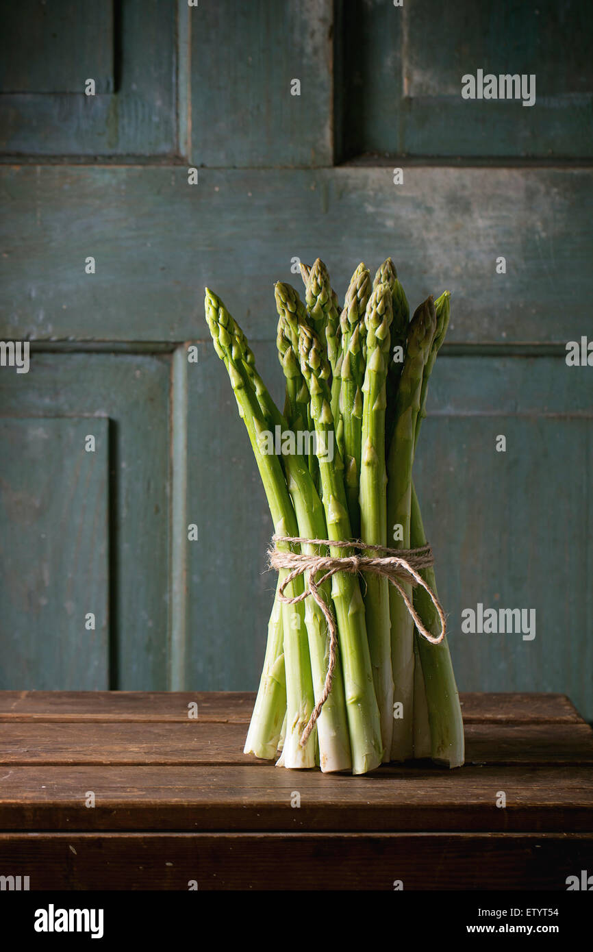 Bundle of green asparagus over wooden table with turquoise wooden ...