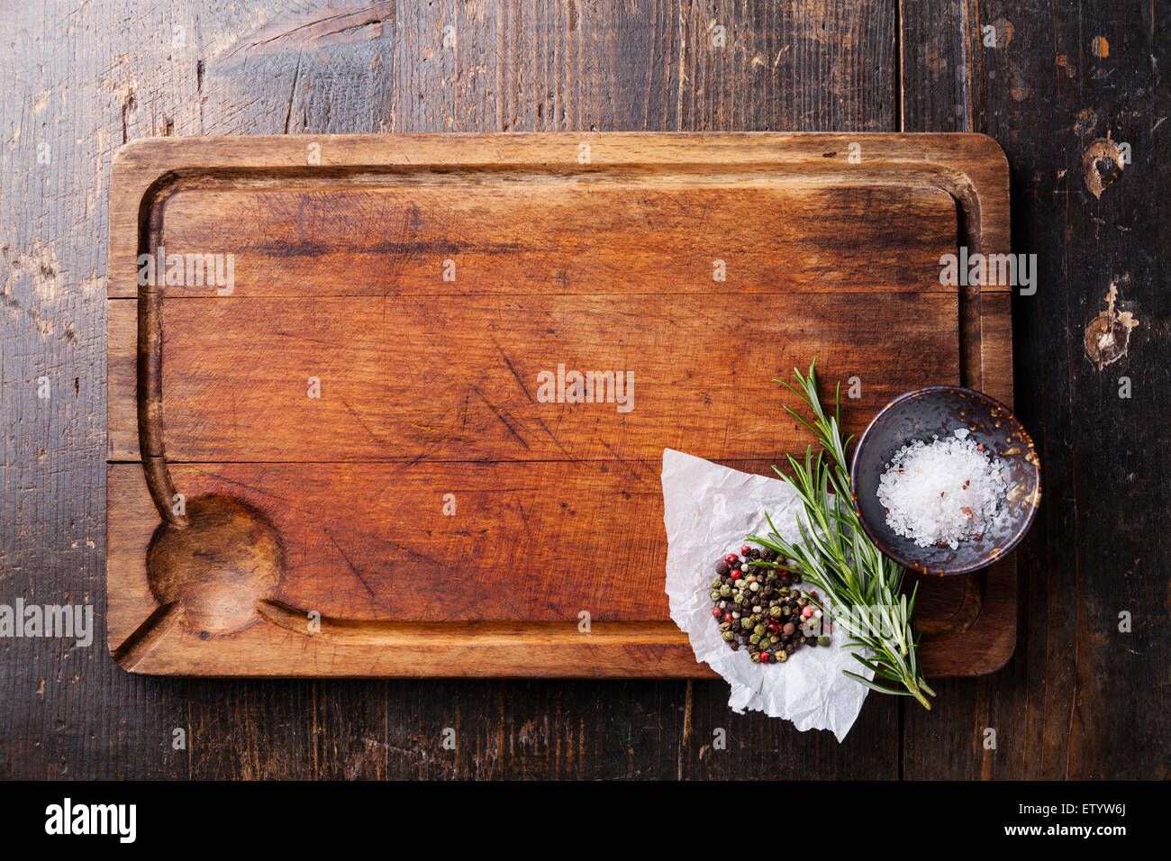 Chopping board, seasonings and rosemary on dark wooden background Stock Photo - Alamy