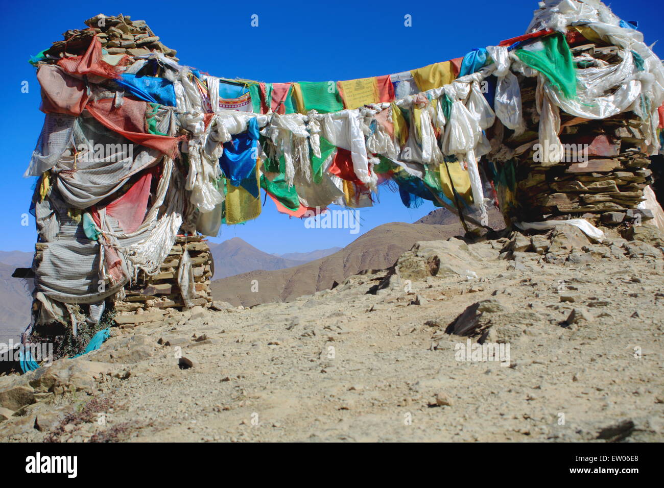 Five colored prayer flags hanging from cairns-stacked stones seemingly ...