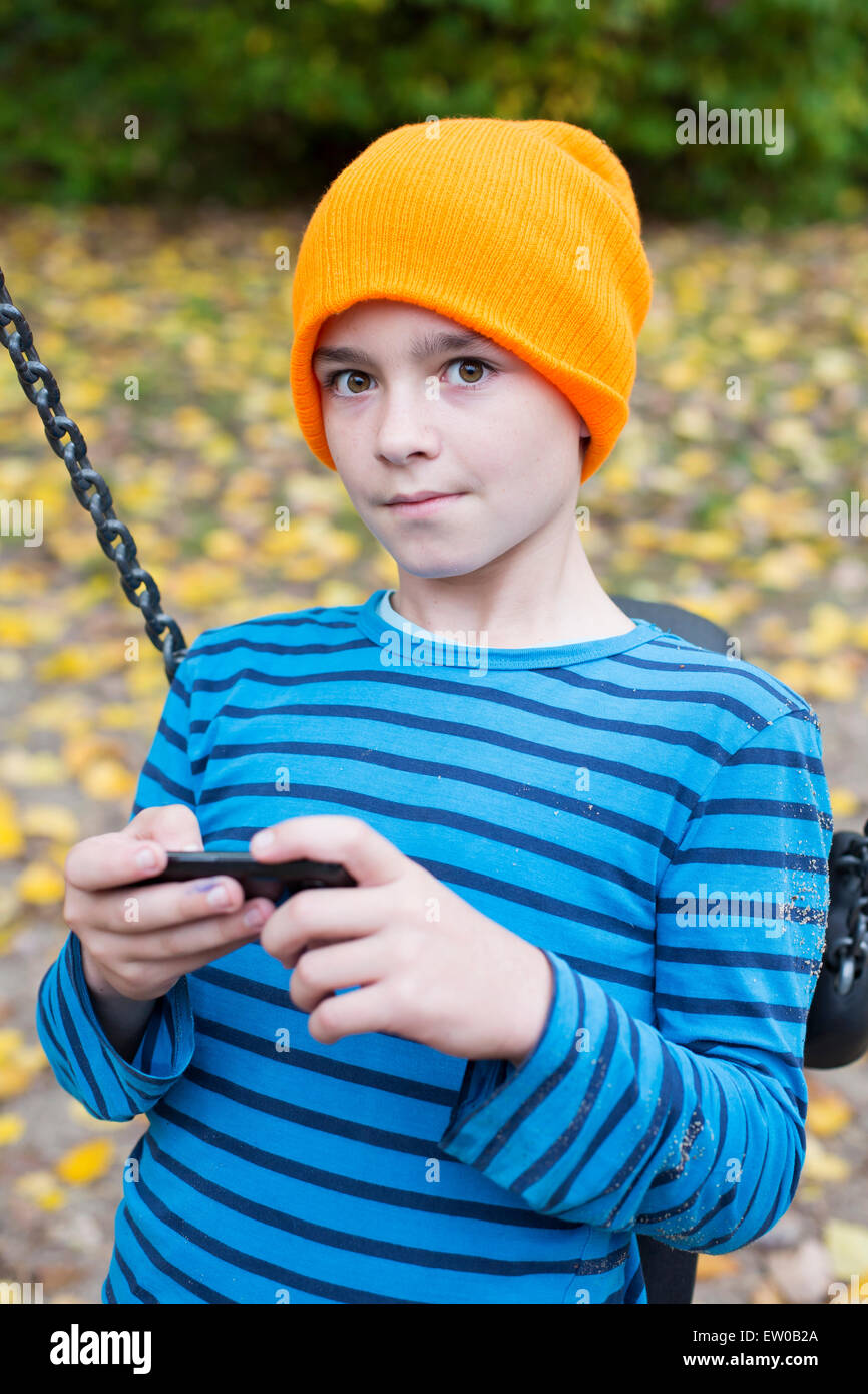 young boy standing outside and holding a phone Stock Photo - Alamy