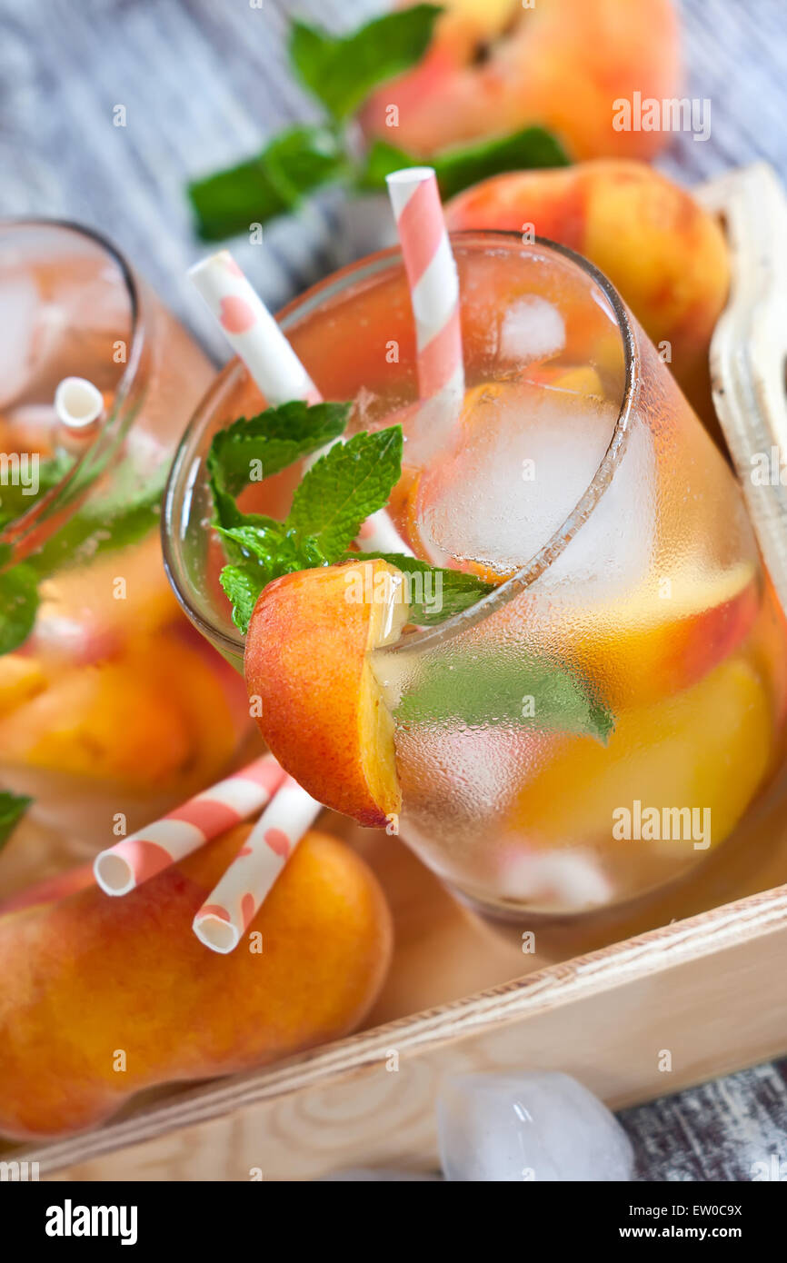 Homemade lemonade with ripe flat saturn-shaped peaches and fresh mint ...