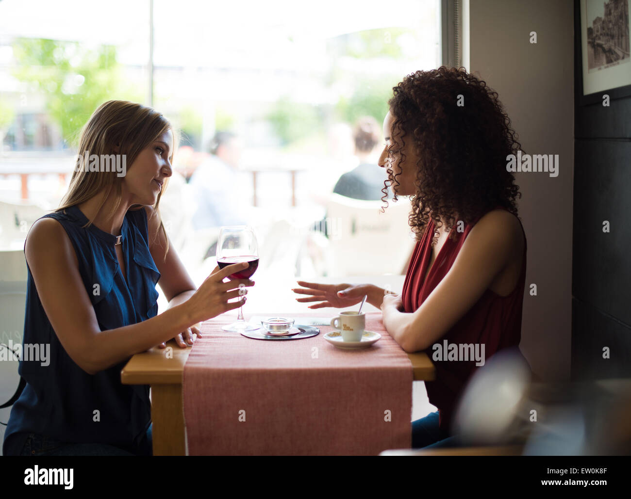 Pretty women talking and having fun inside coffee shop Stock Photo - Alamy