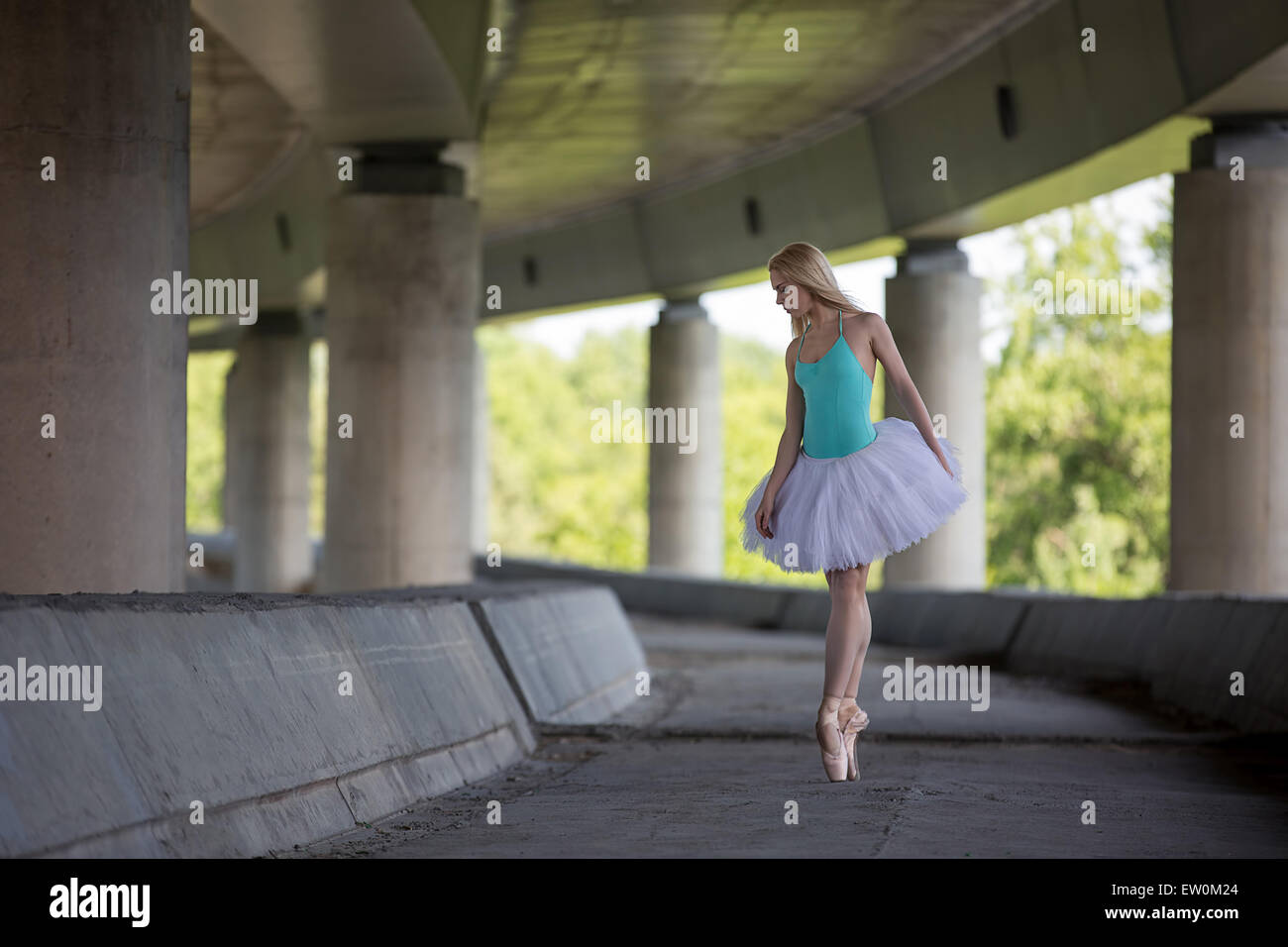 Graceful ballerina doing dance exercises on a concrete bridge Stock ...