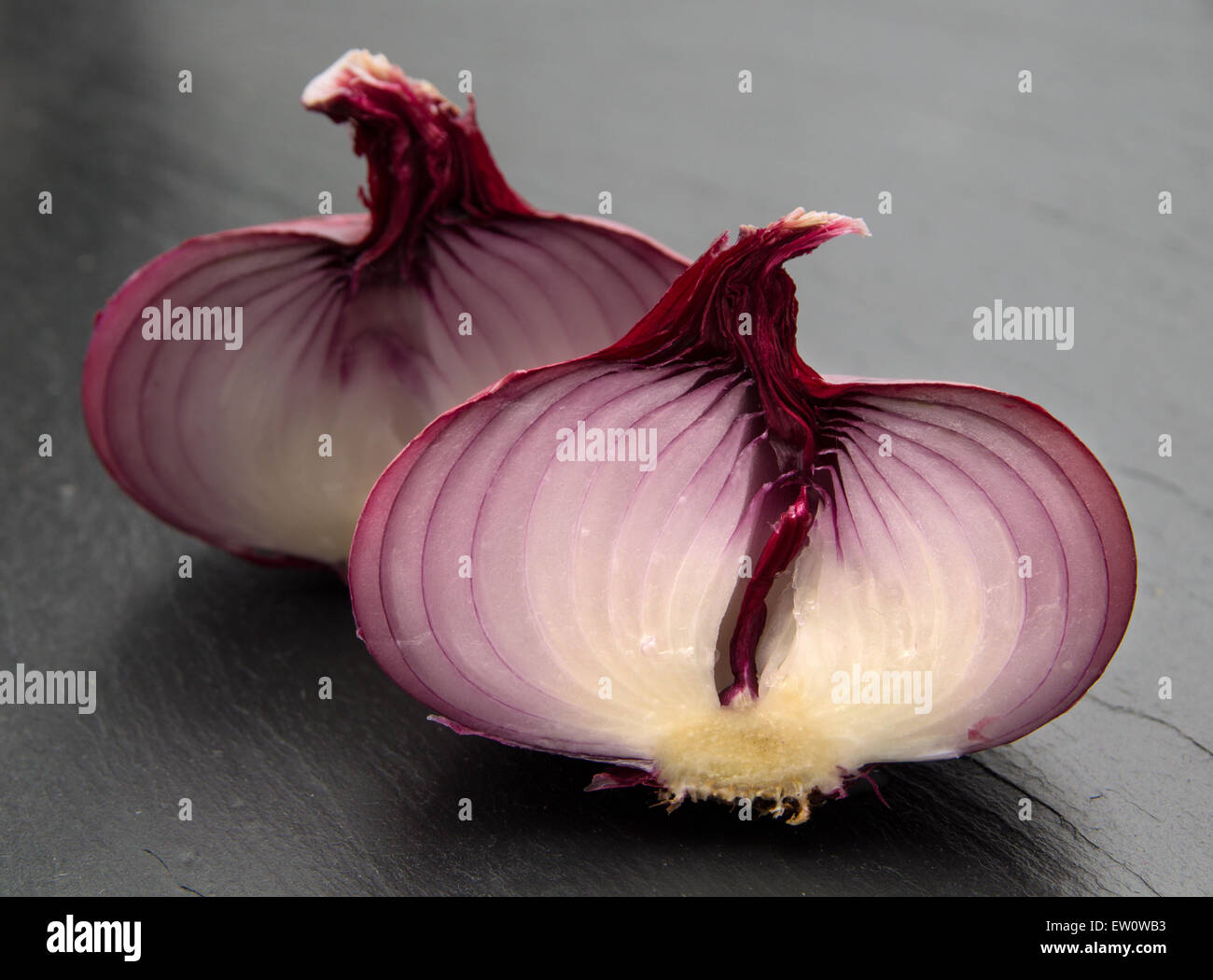 flat red onion cut in half on black slate stone surface Stock Photo - Alamy