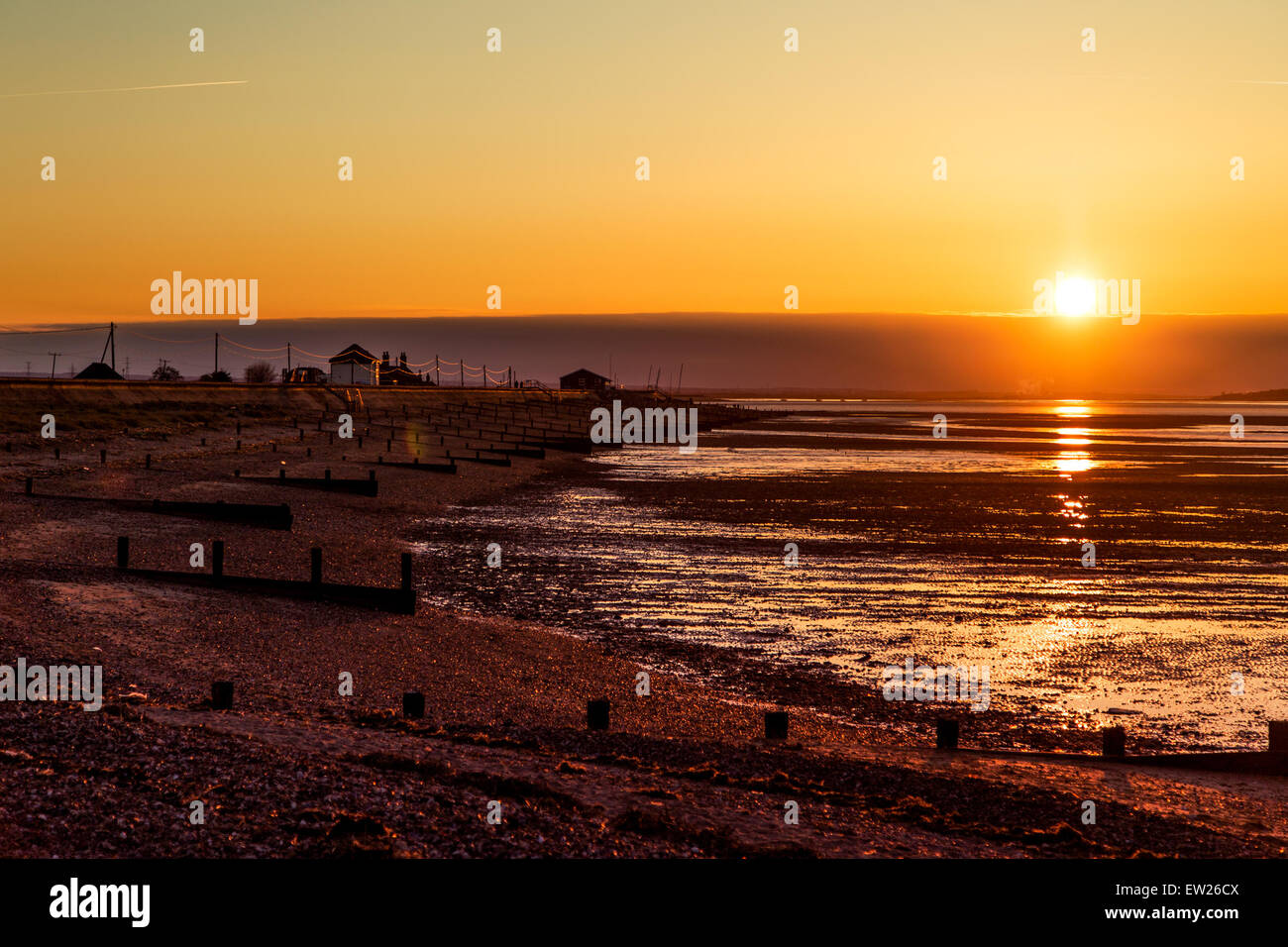 The sun sets over the coast at Seasalter in North Kent. Featuring ...