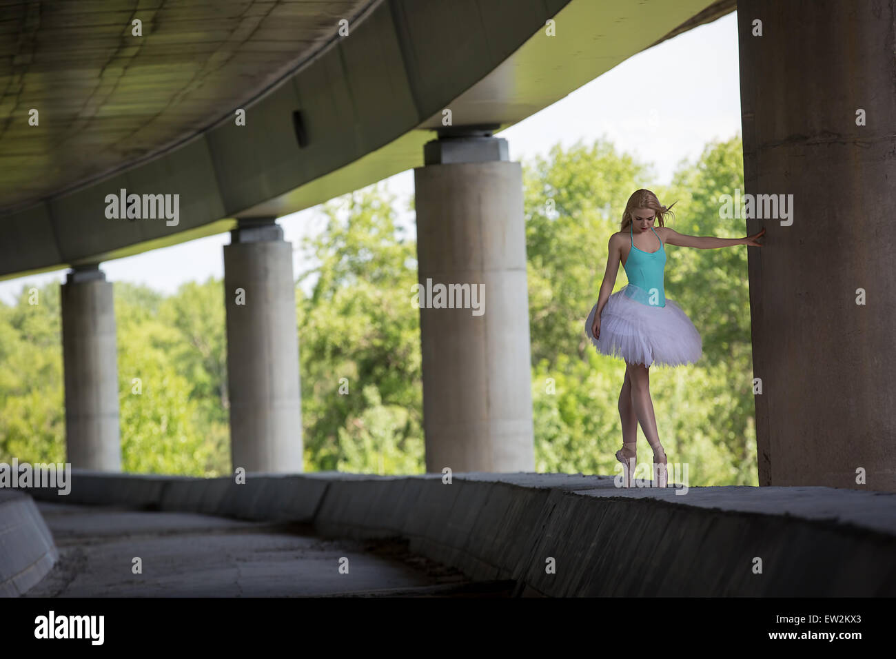 Graceful ballerina doing dance exercises on a concrete bridge Stock ...