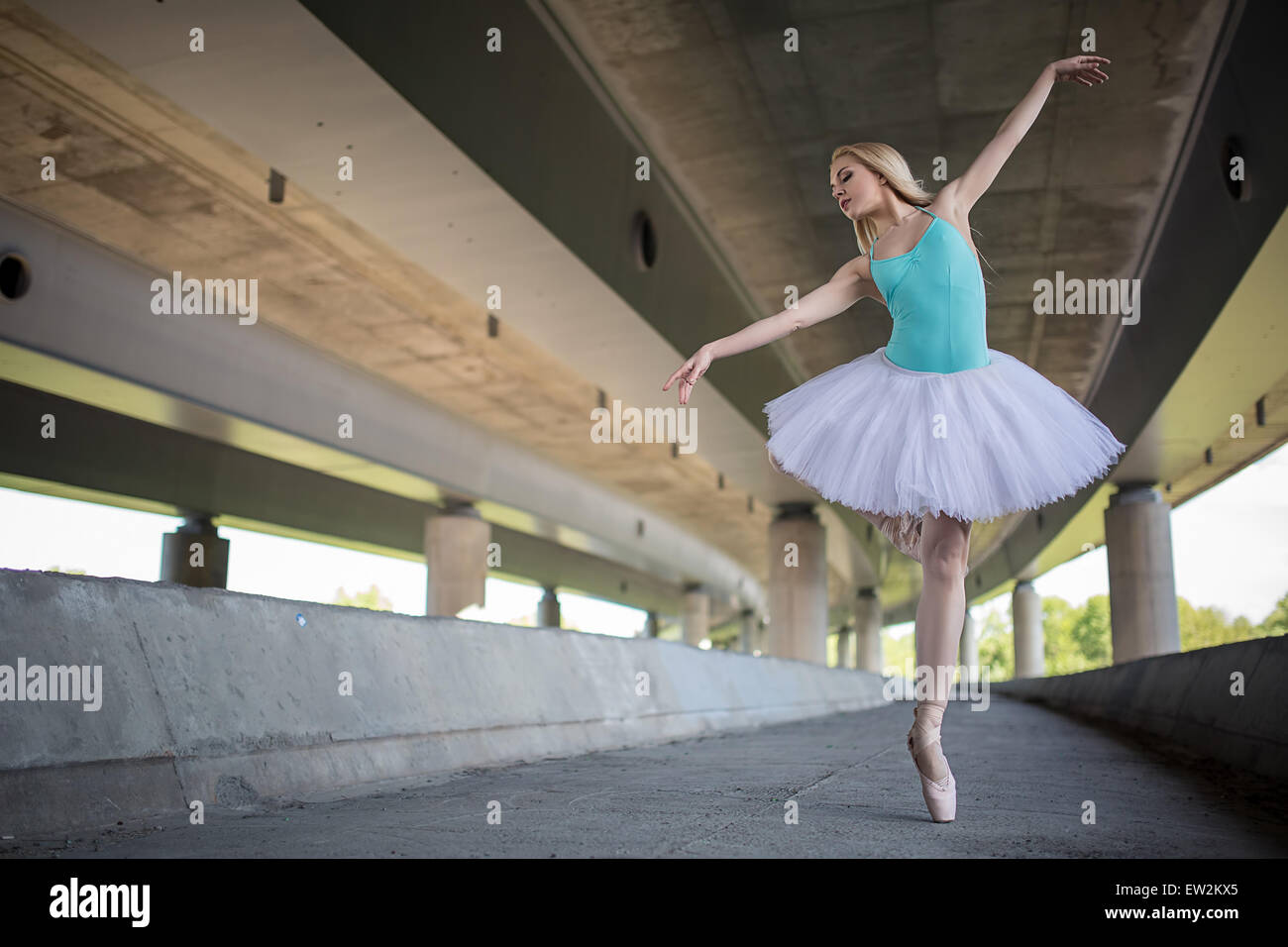 Graceful ballerina doing dance exercises on a concrete bridge Stock ...