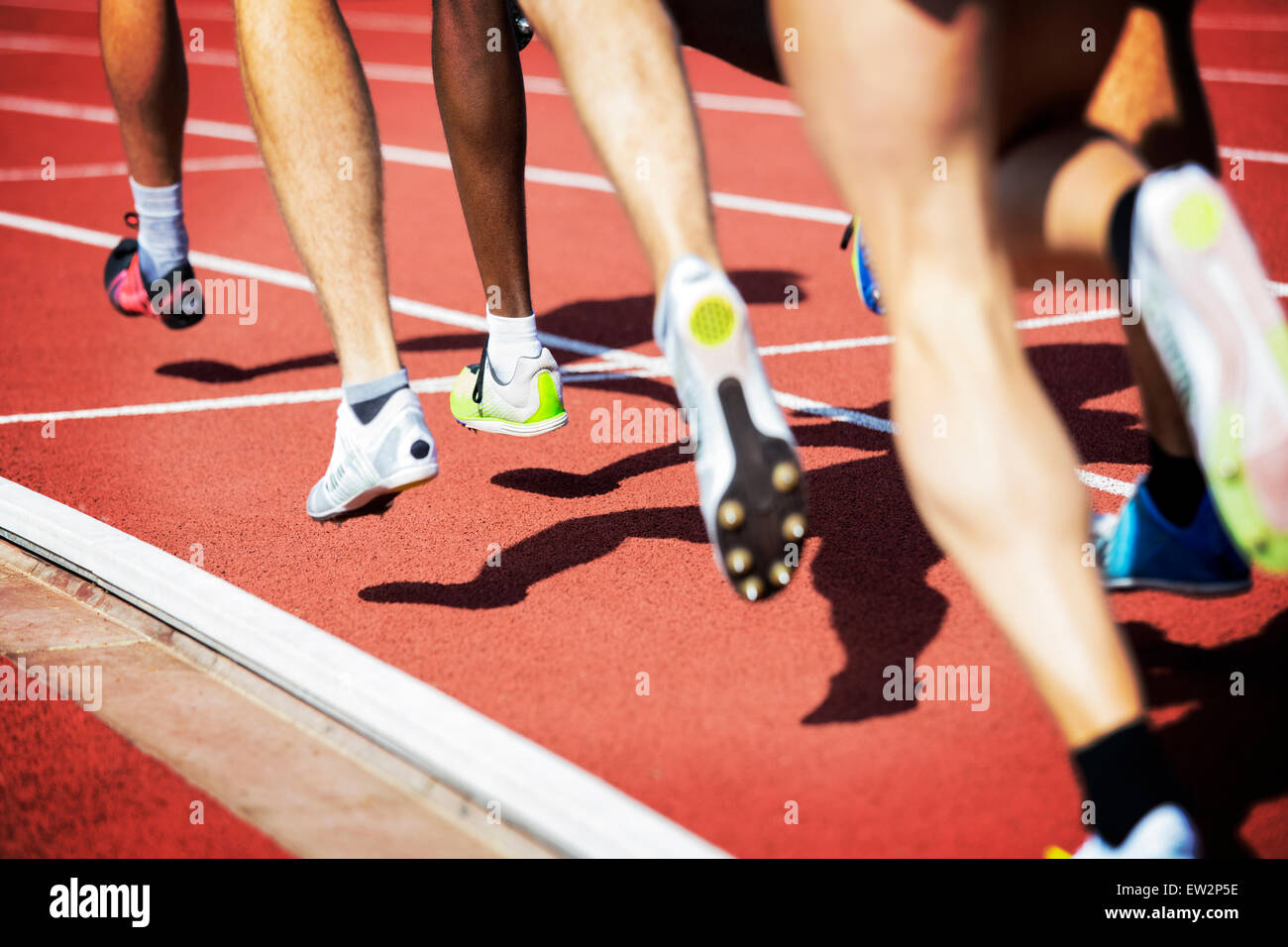 Runner legs in a stadium. Focus is on runner with dark skin Stock Photo ...