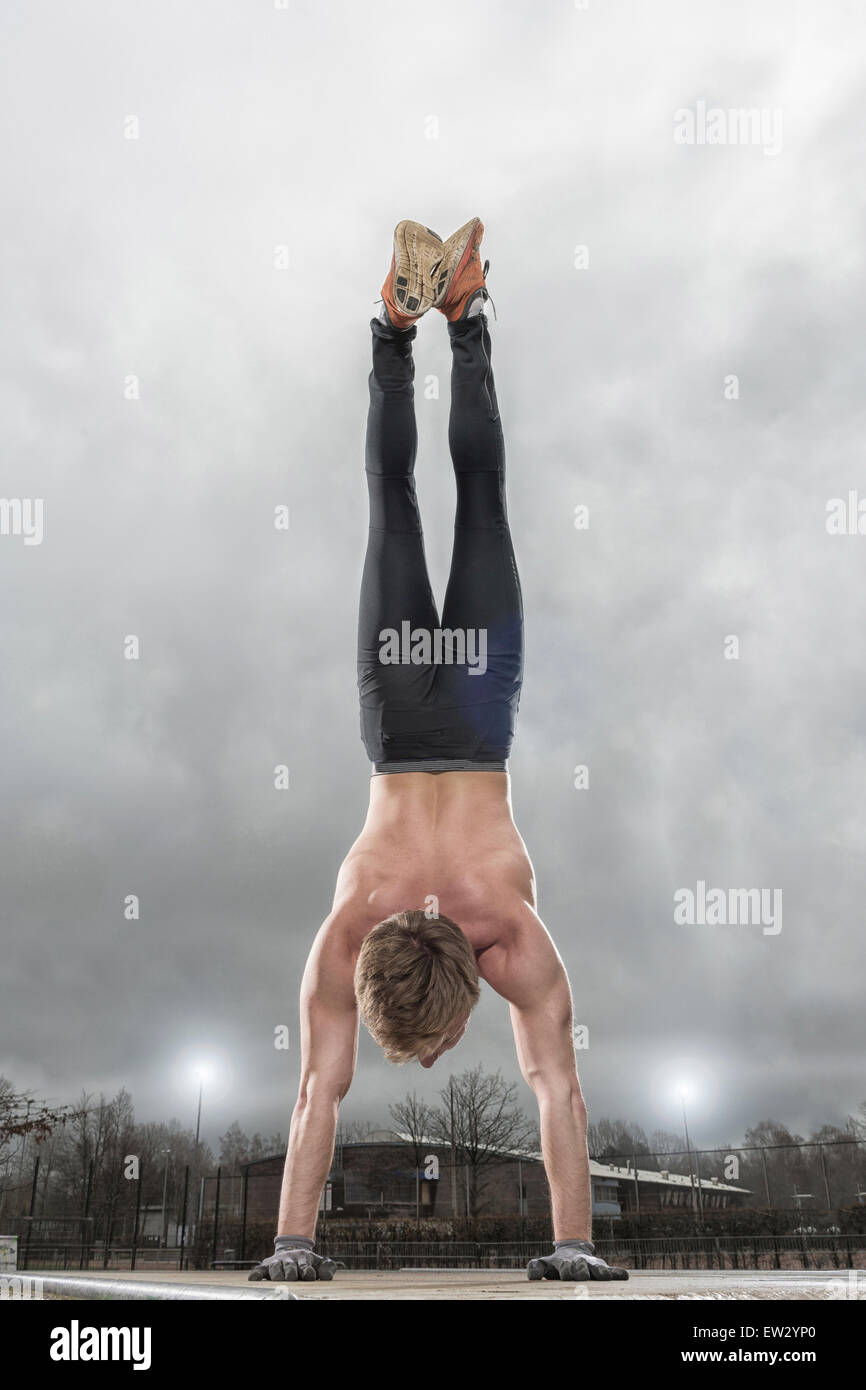 Handstand in front of grey sky Stock Photo - Alamy