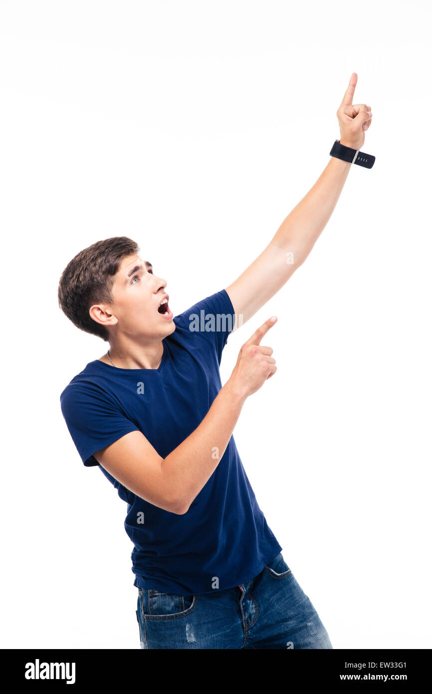 Shocked young man pointing finger up isolated on a white background ...