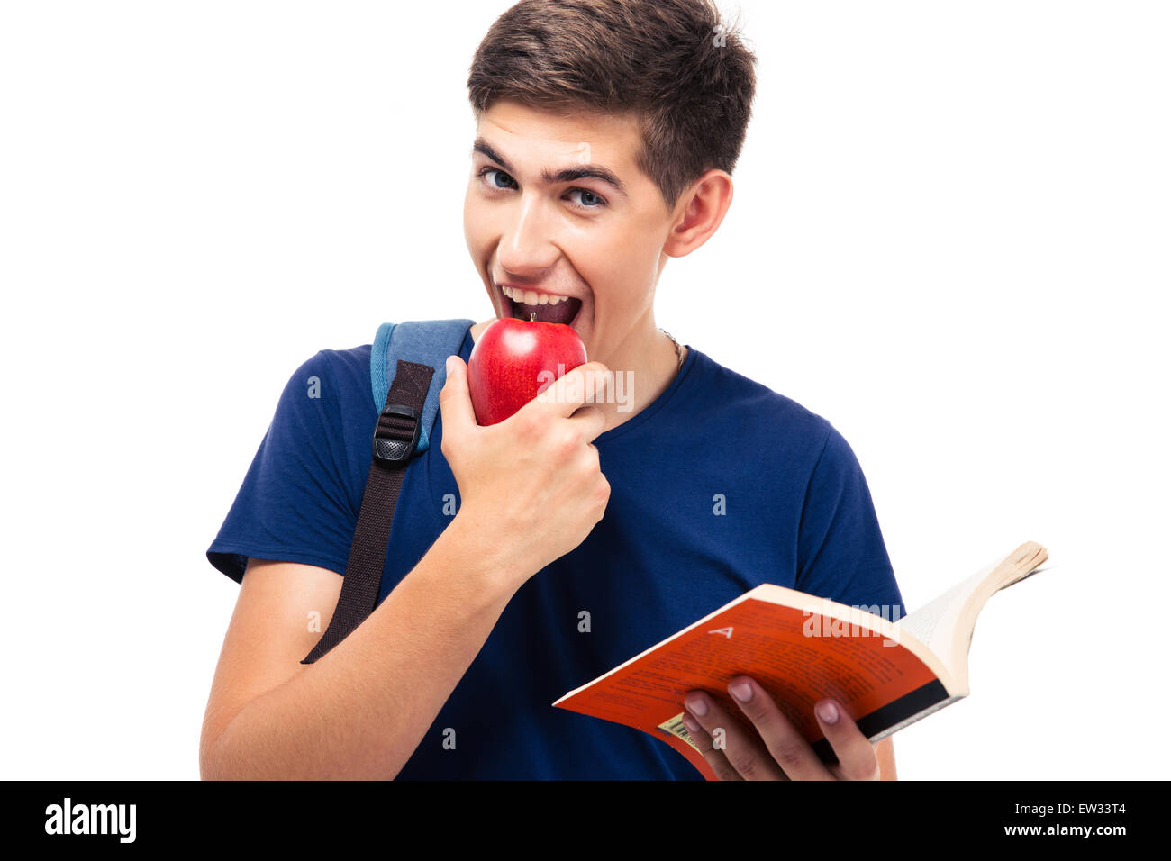 Happy male student biting apple and reading book isolated on a white ...