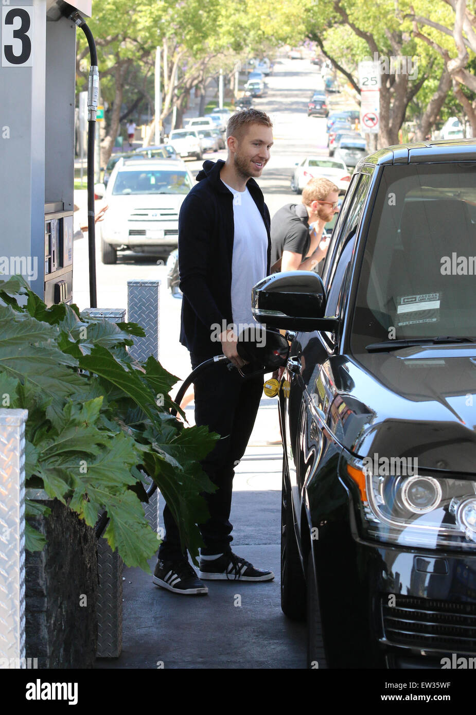 Calvin Harris pumping gas at a garage in West Hollywood for his black ...
