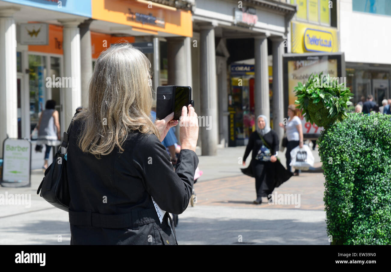 Lady taking photo on mobile phone, Long Row, Nottingham, England Stock ...