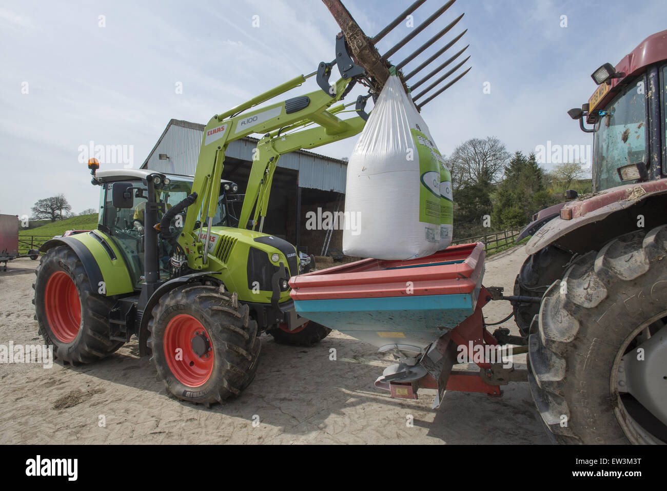 Claas tractor with front loader forks, loading big bags of fertiliser ...