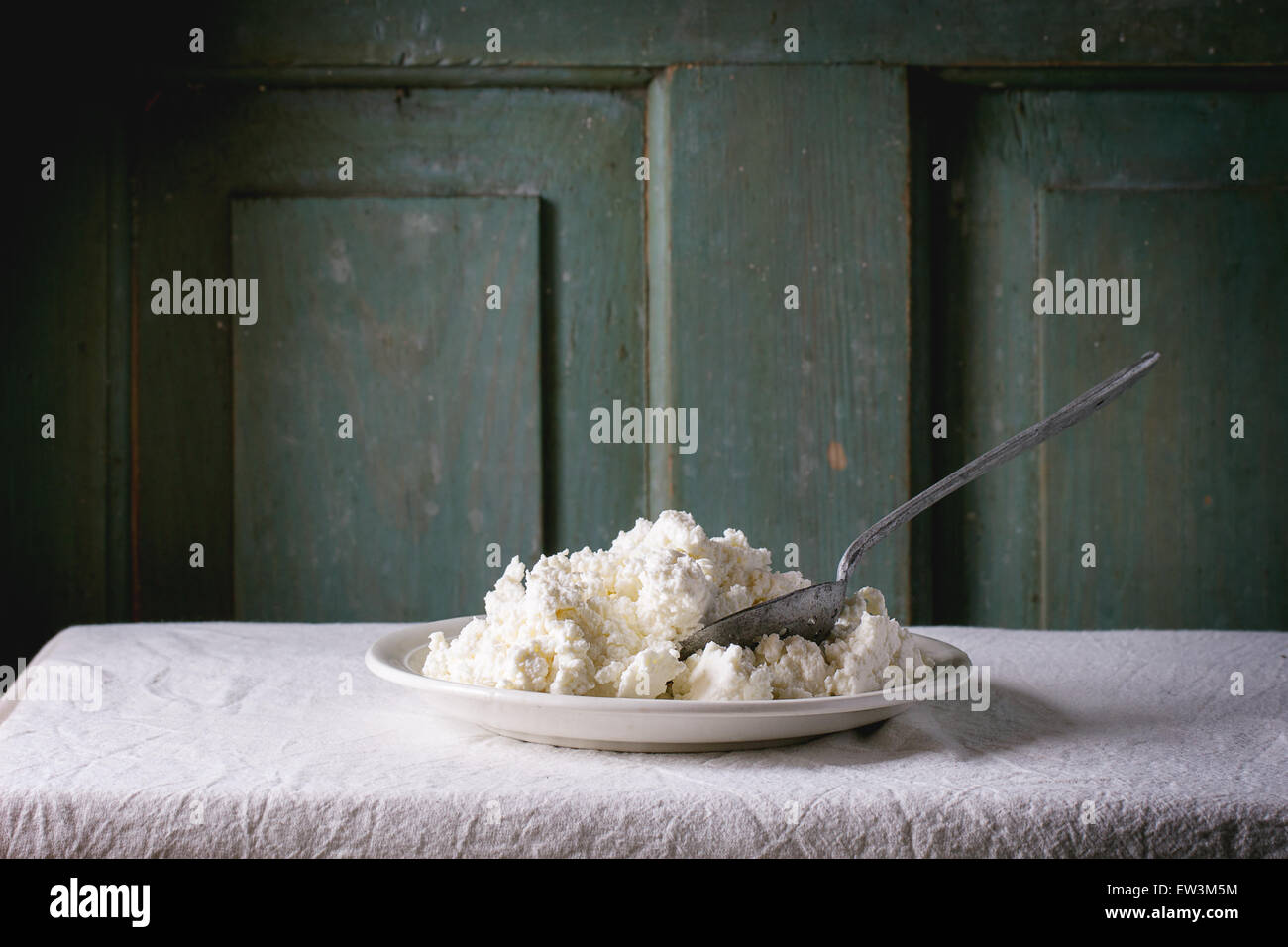 Plate of homemade cottage cheese on white tablecloth with turquoise ...