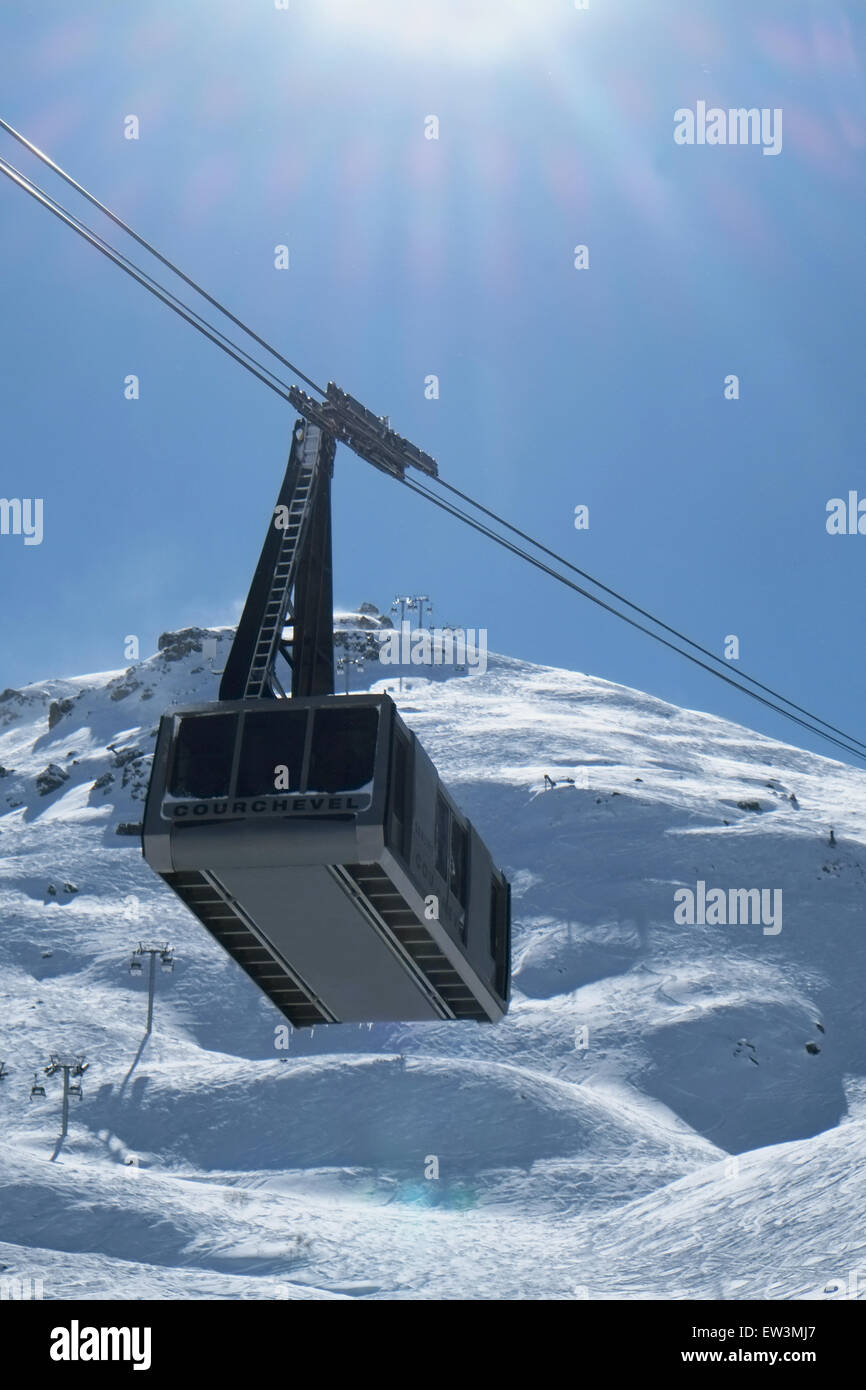 a cable car with snowy mountain behind it beginning journey up Stock ...