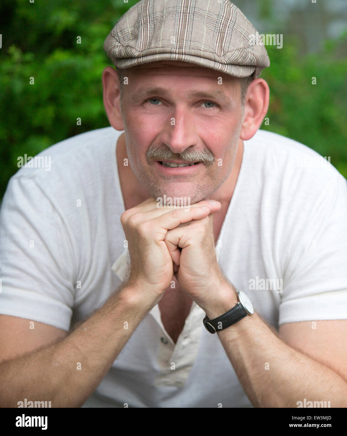 portrait of a man sitting on a bench in a park Stock Photo - Alamy