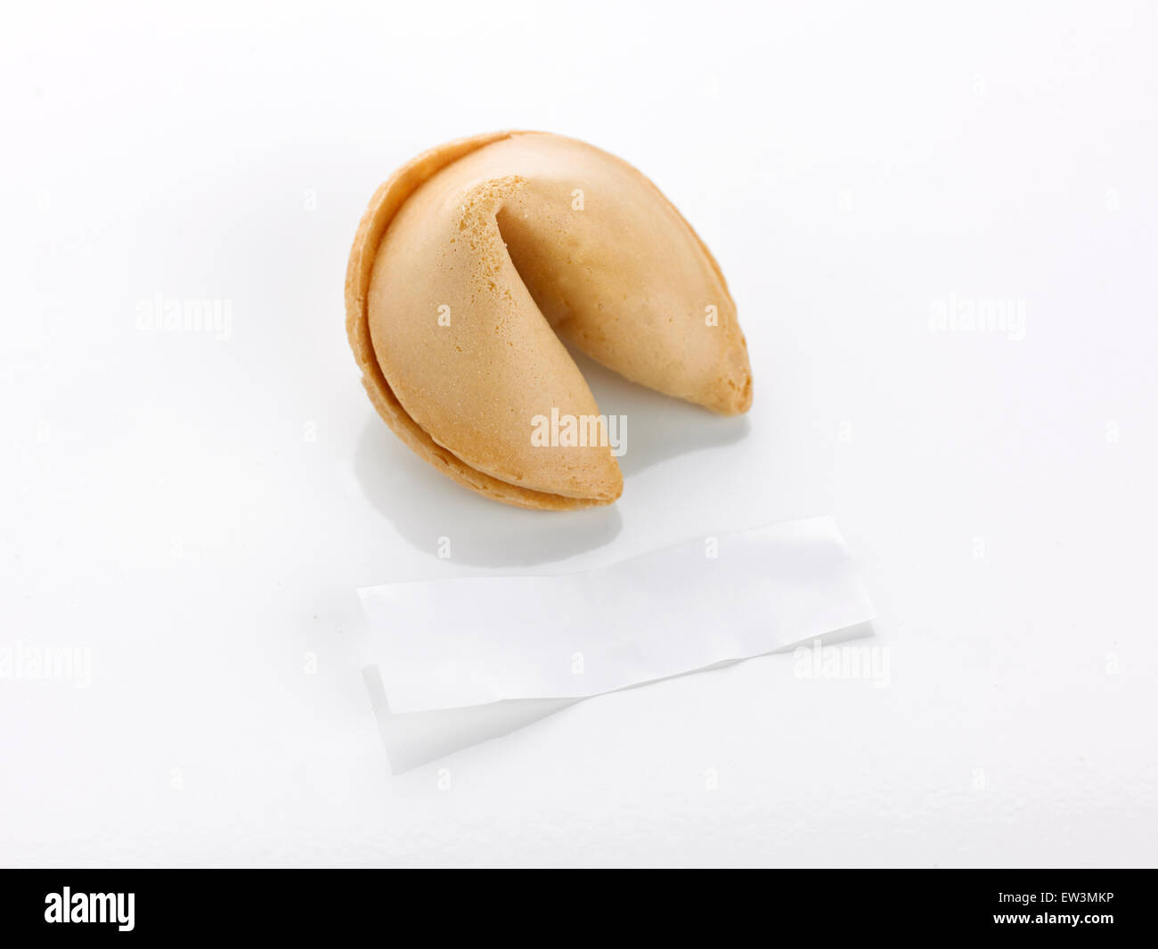a single unopened fortune cookie on a white background with blank paper ...