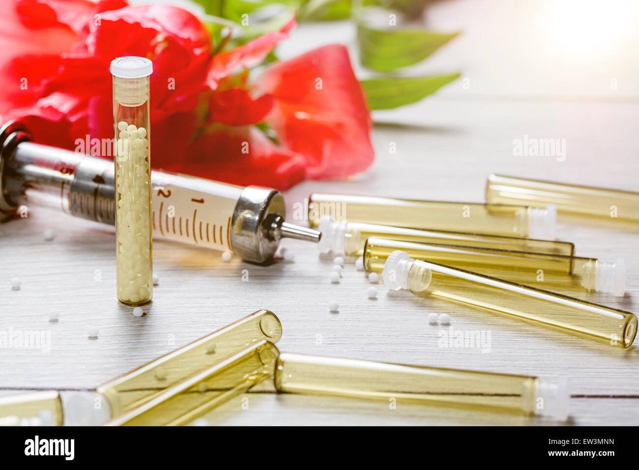 small glass tubes with homeopathic medicine, syringe and flower Stock ...