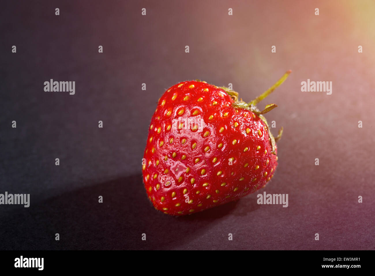 single strawberry with black background Stock Photo - Alamy